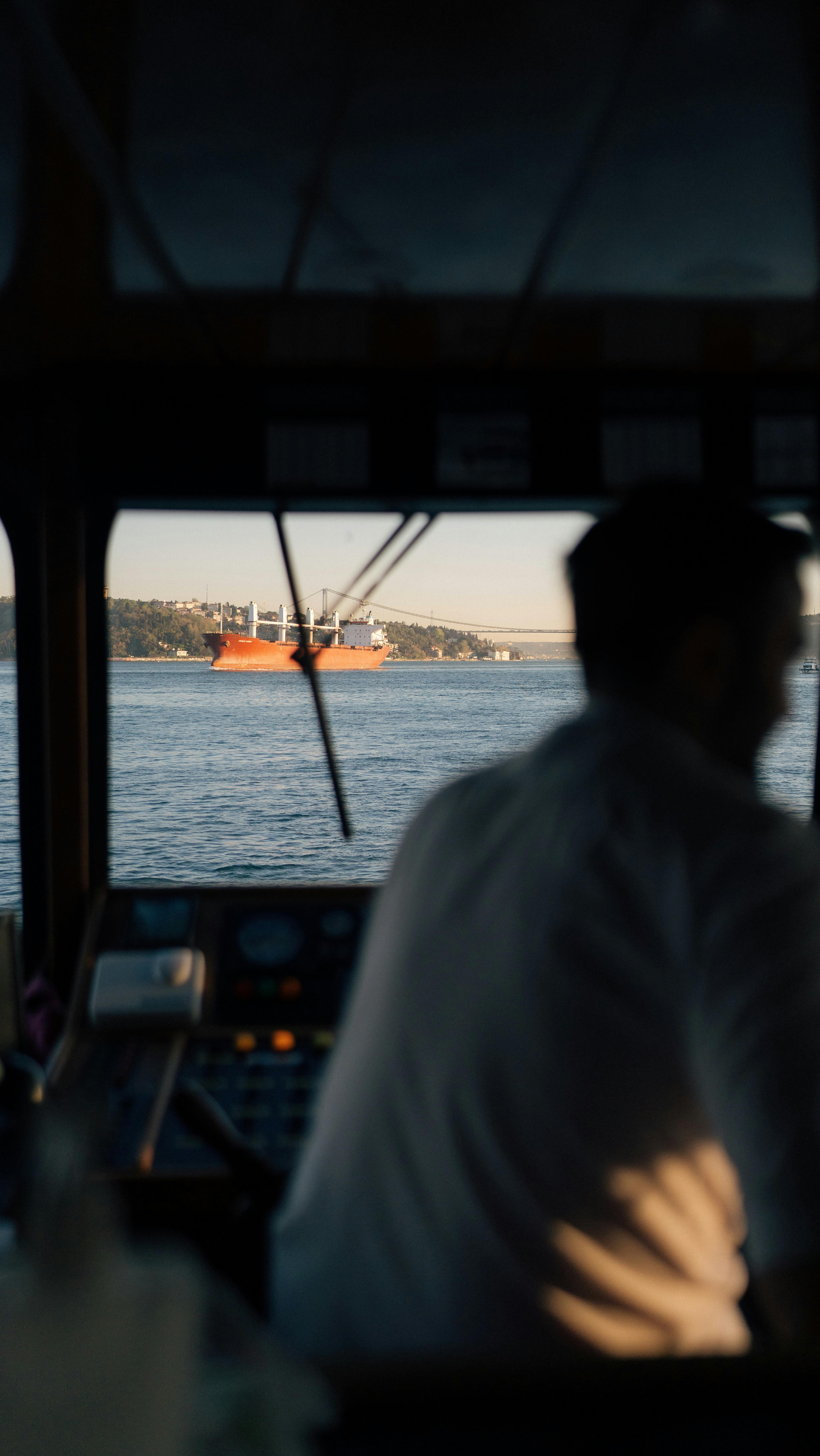 Sailor on the Bridge of a Ship and a Tanker in Front in the Harbor ...