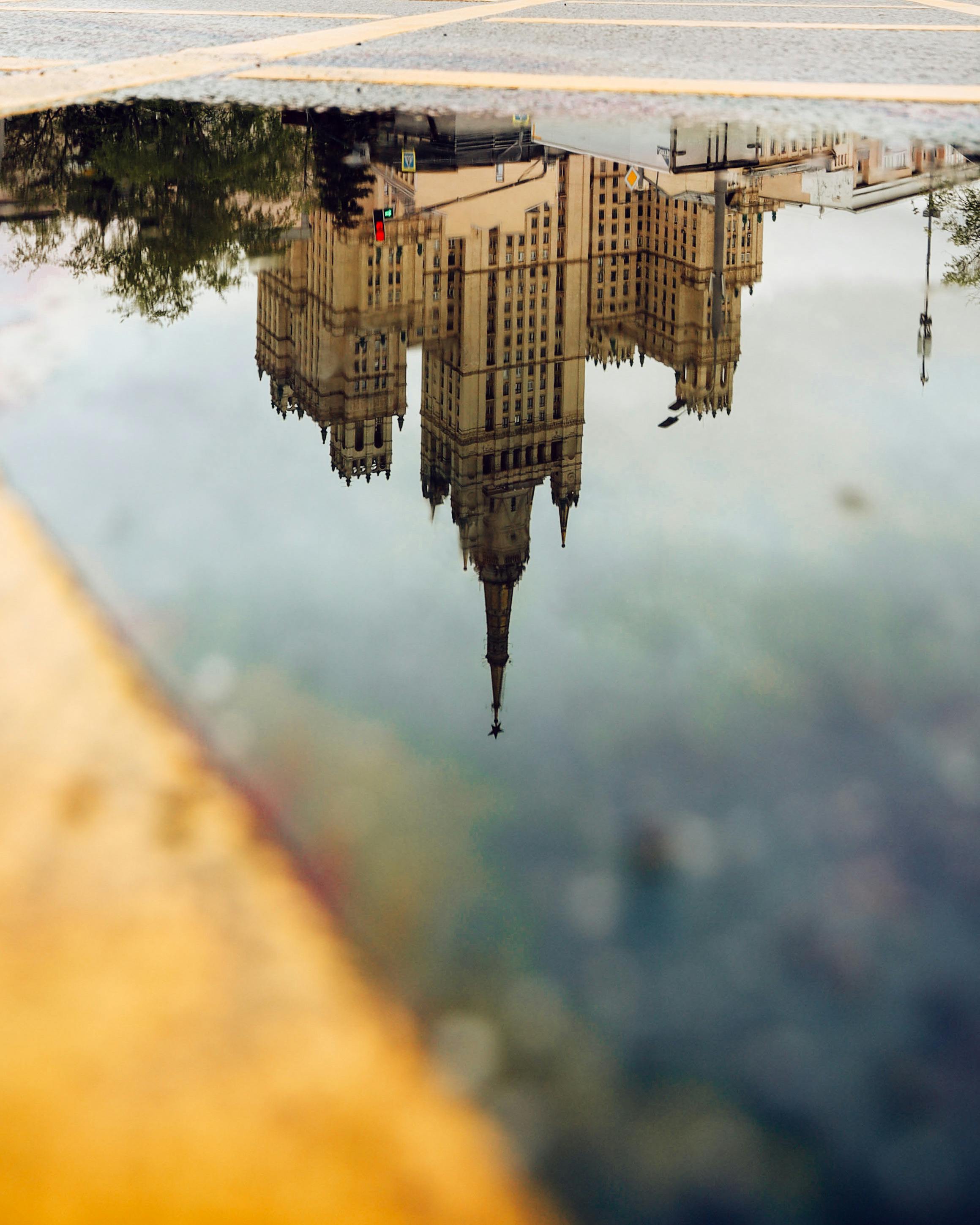A reflection of a building in a puddle · Free Stock Photo