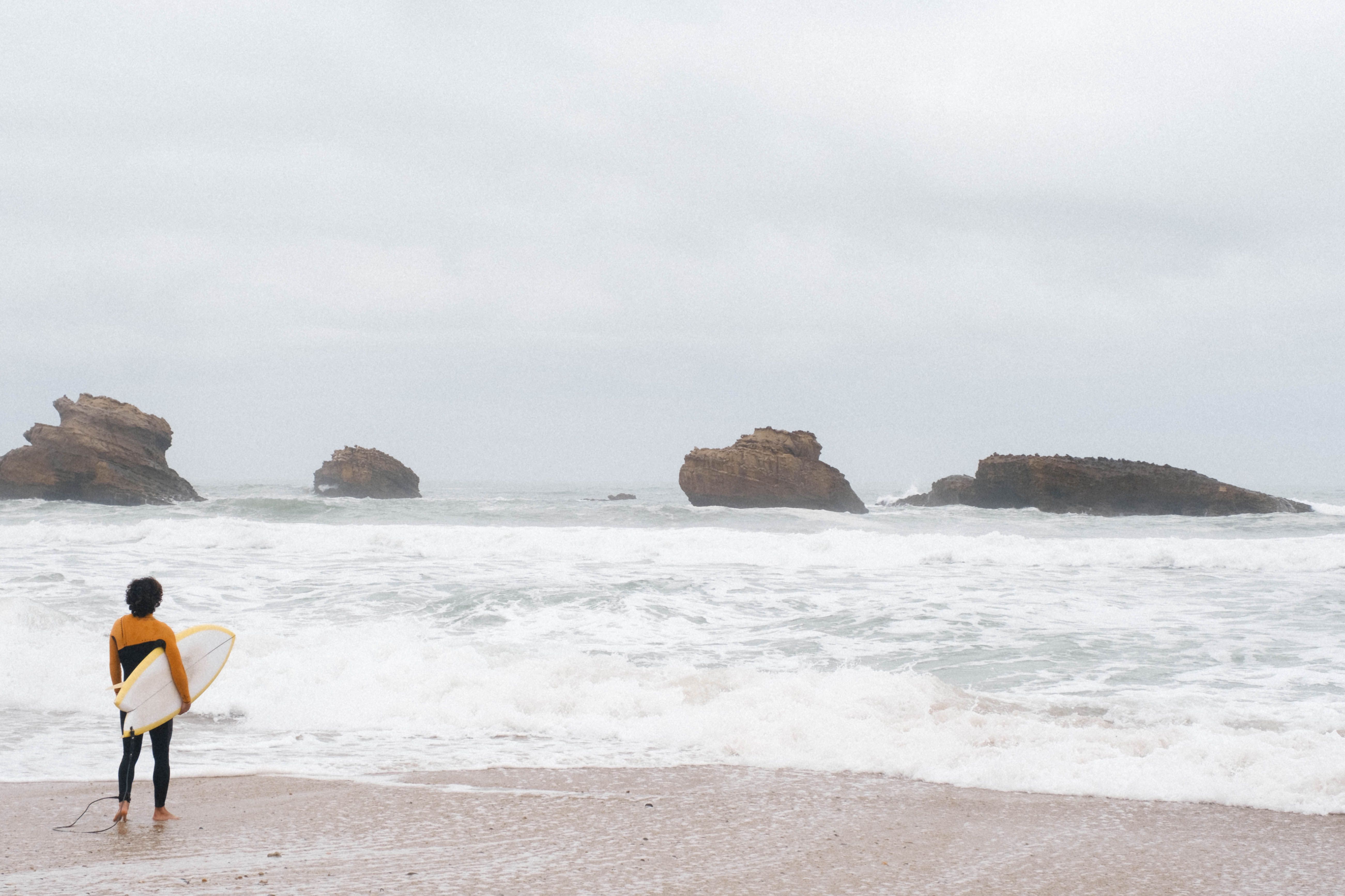 Surfer with Surfboard on Beach · Free Stock Photo