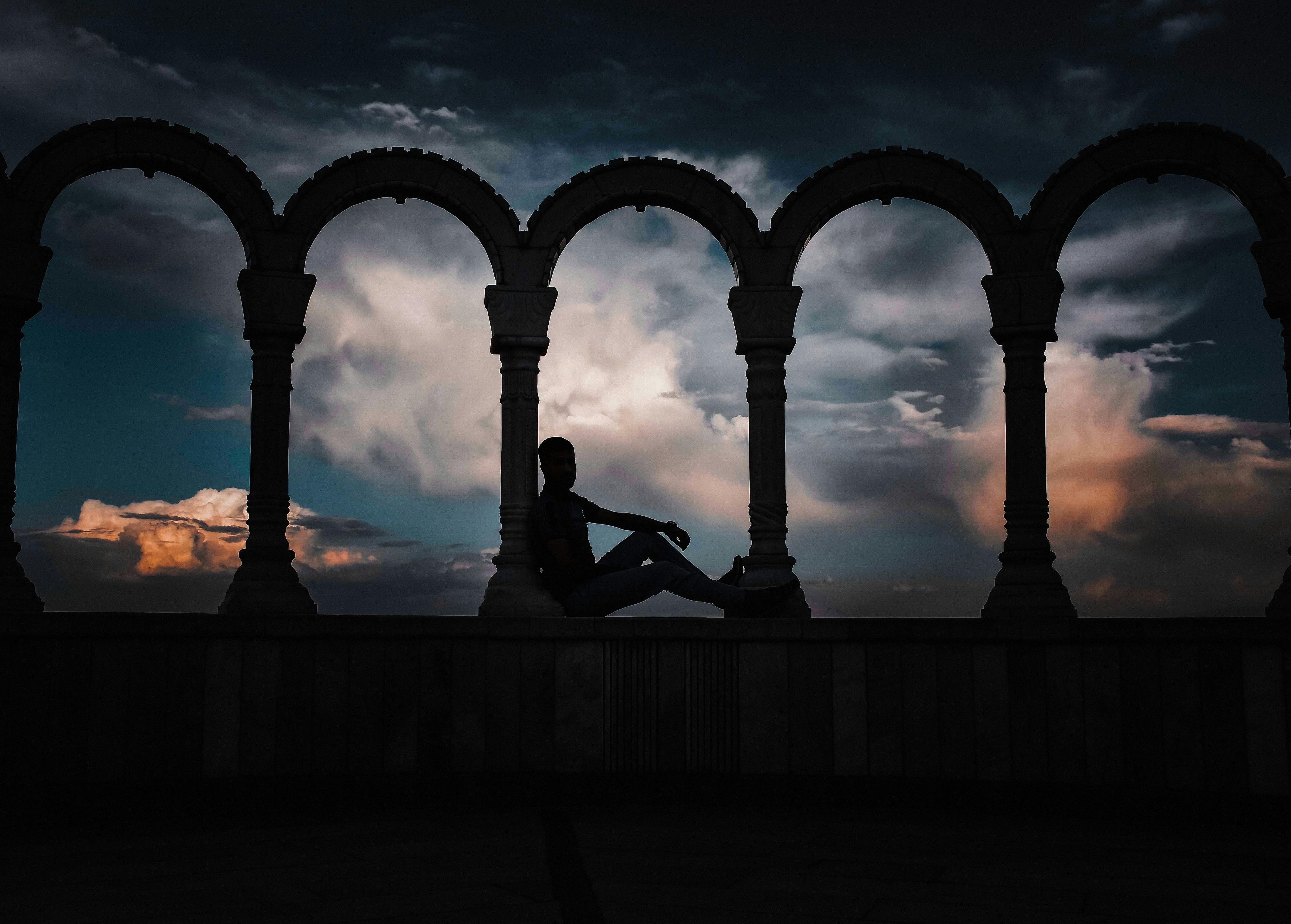Silhouette Photo of Person Leaning on Arch Pillar · Free Stock Photo