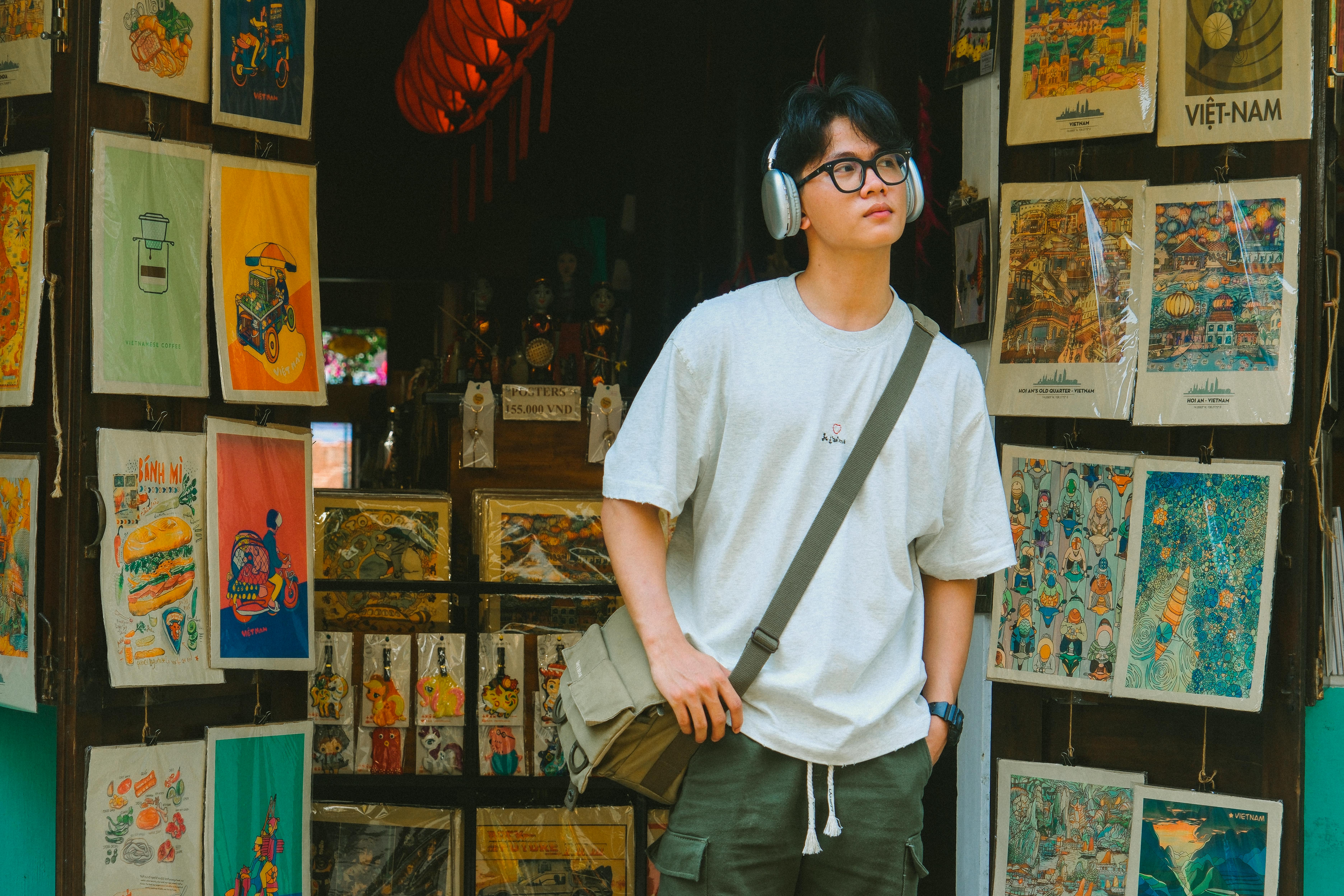 Man in White T-Shirt Posing in Store with Souvenirs · Free Stock Photo