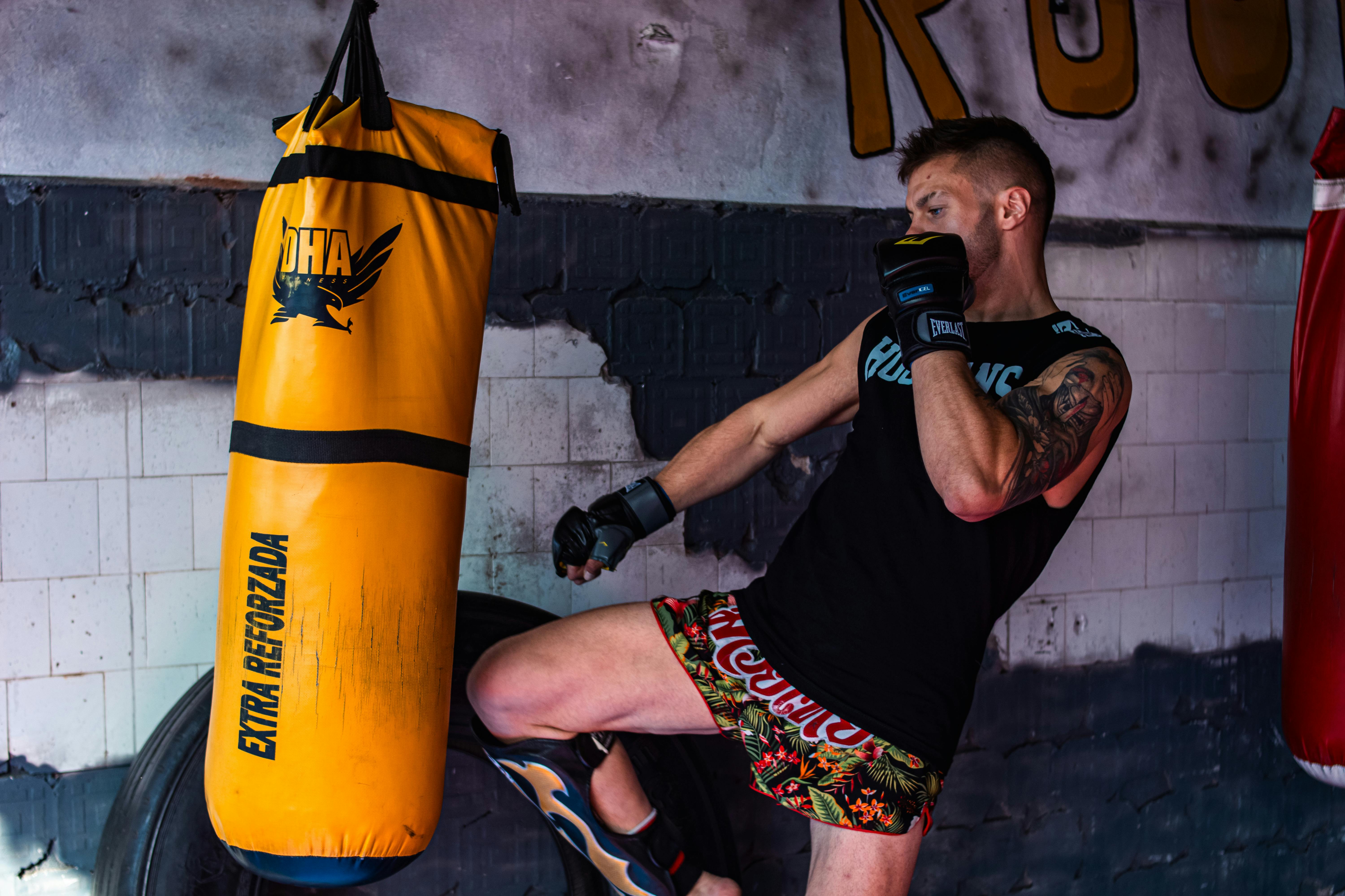 Muai Thai Boxer with Boxing Gloves and Leg Pads Kicking Punching Bag ...
