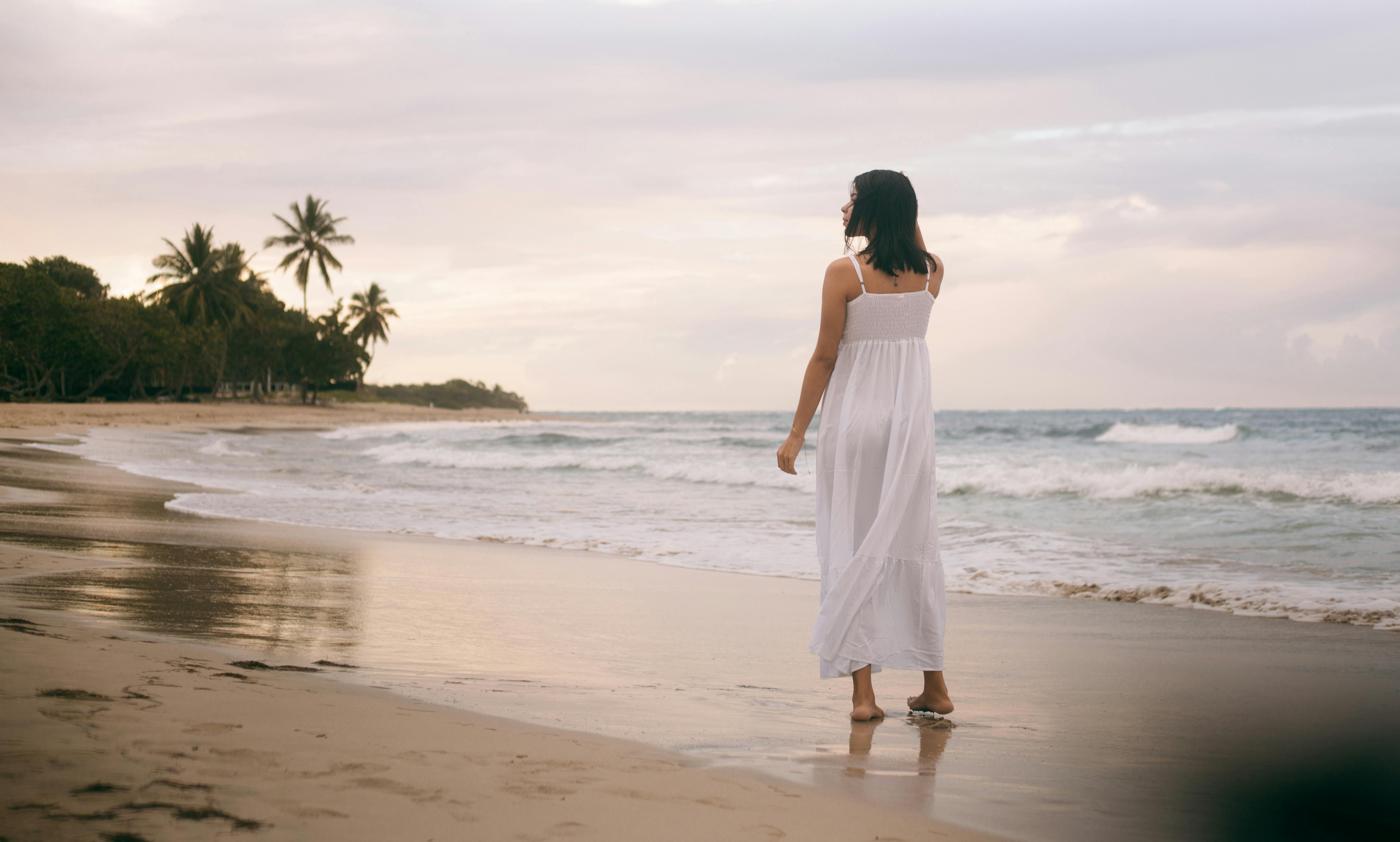 Back View of a Woman Walking on the Beach · Free Stock Photo