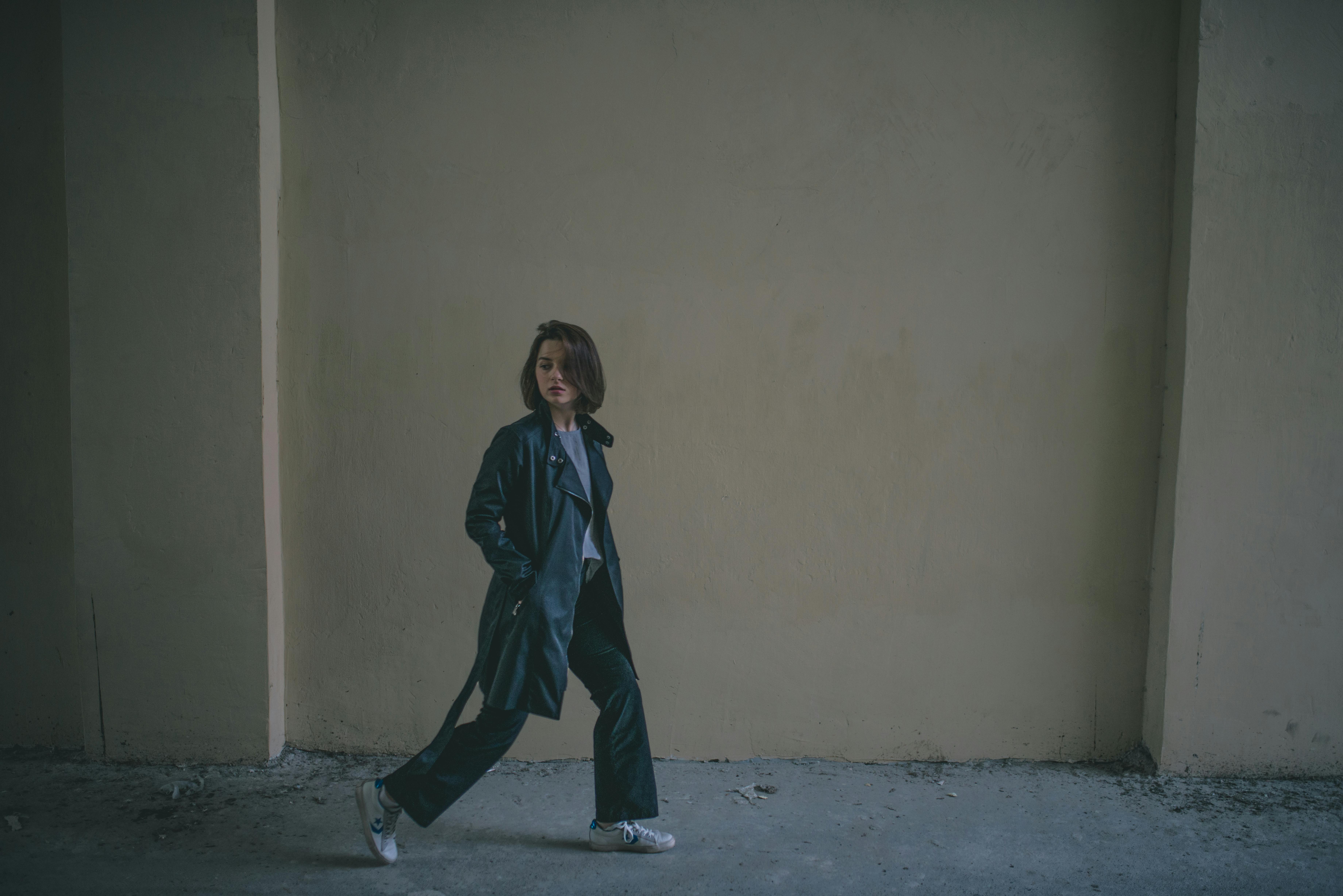 Woman Walking Near Wall · Free Stock Photo