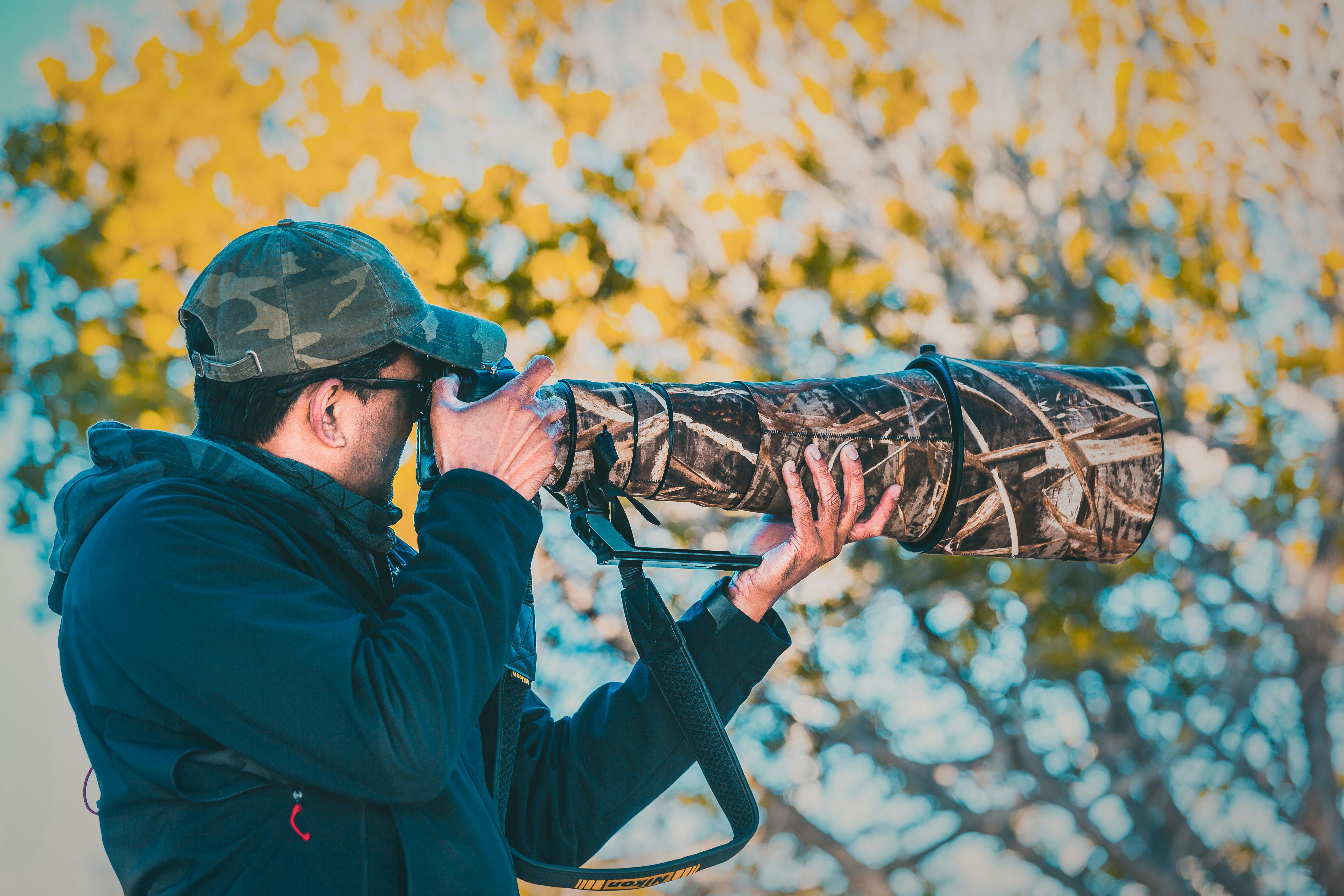 Man Using Gray and Black Dslr Camera With Telephoto Lens · Free Stock Photo