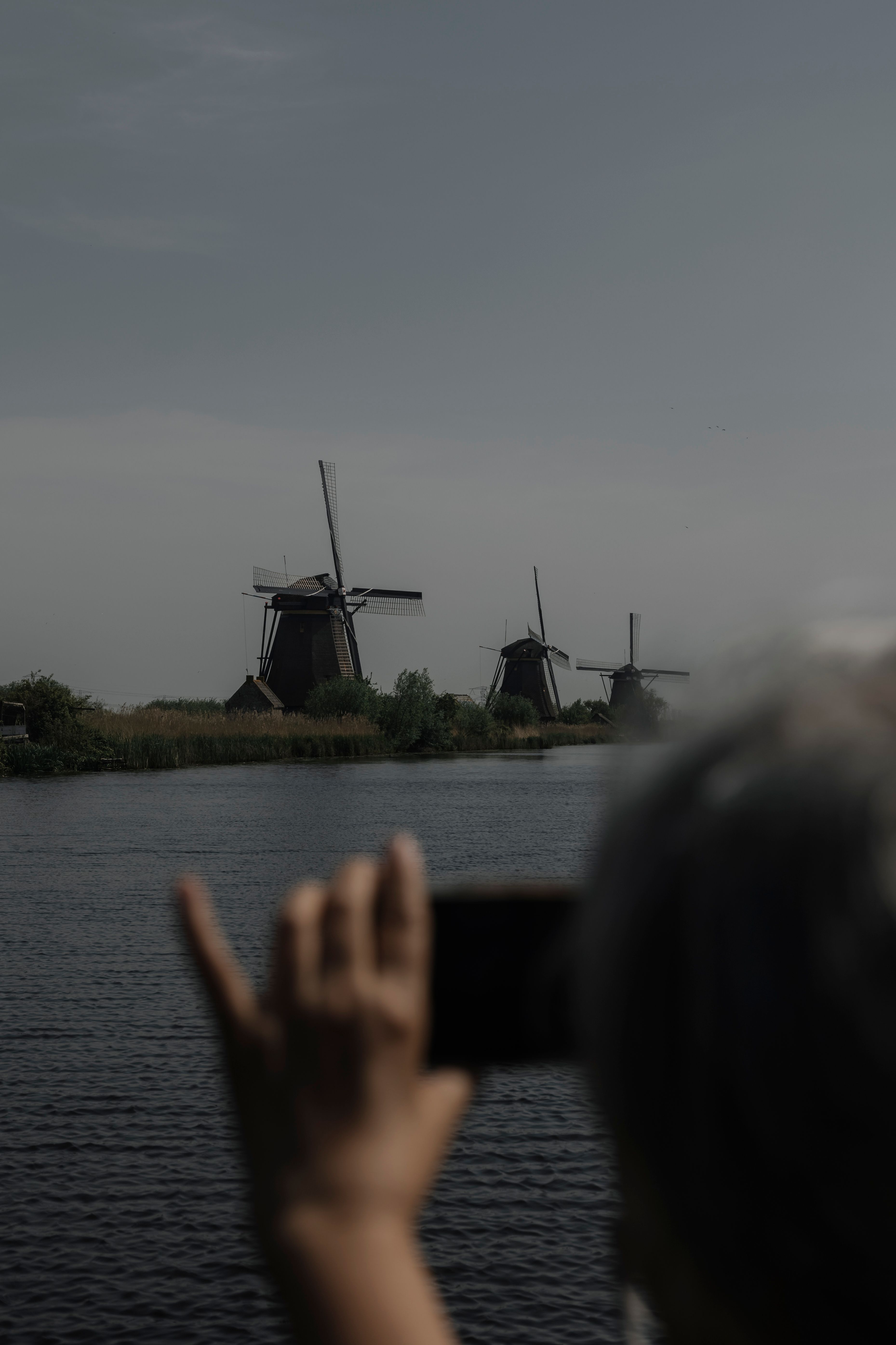 A person taking a photo of a windmill · Free Stock Photo