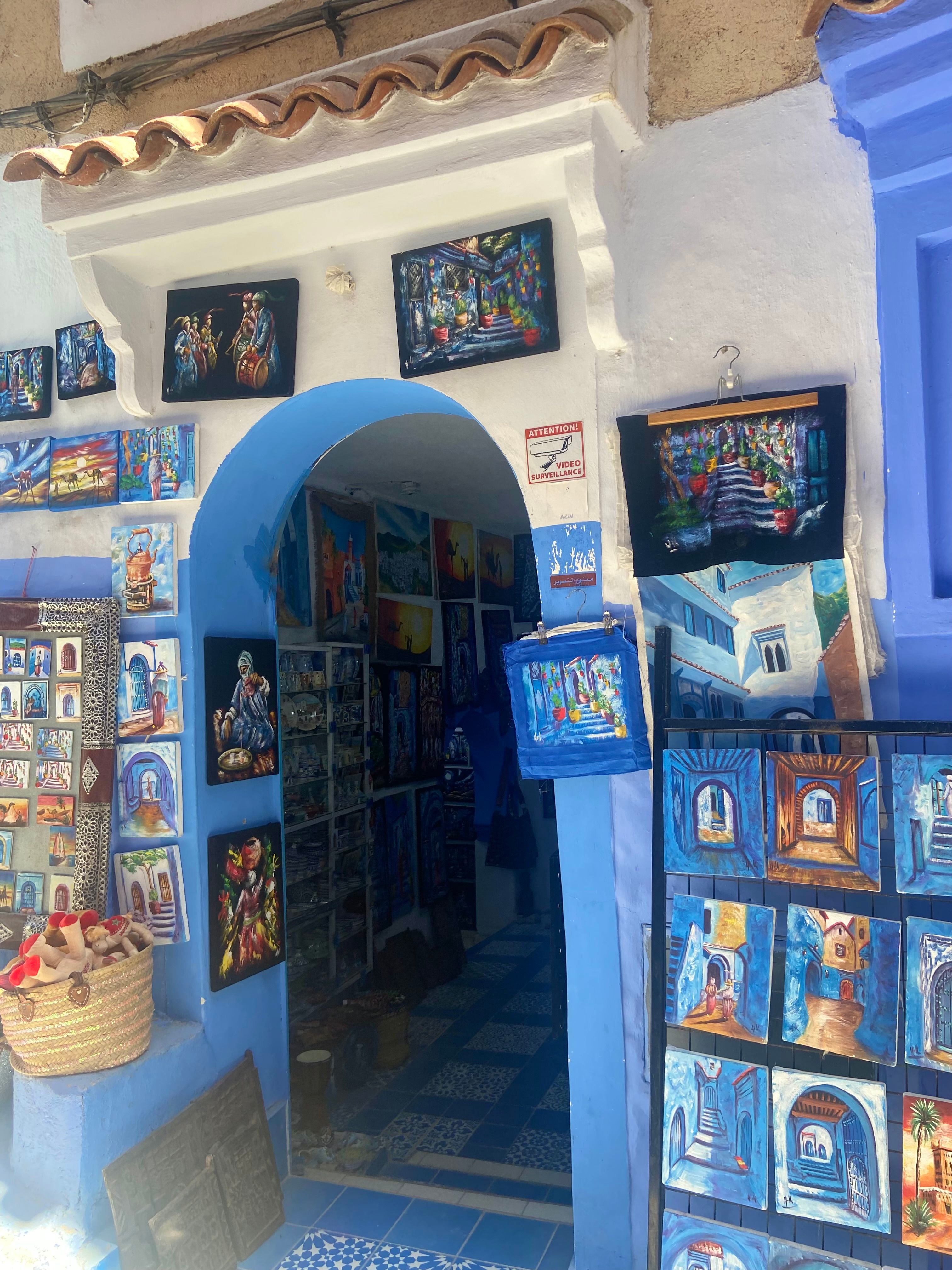 A blue and white shop with paintings on the walls · Free Stock Photo