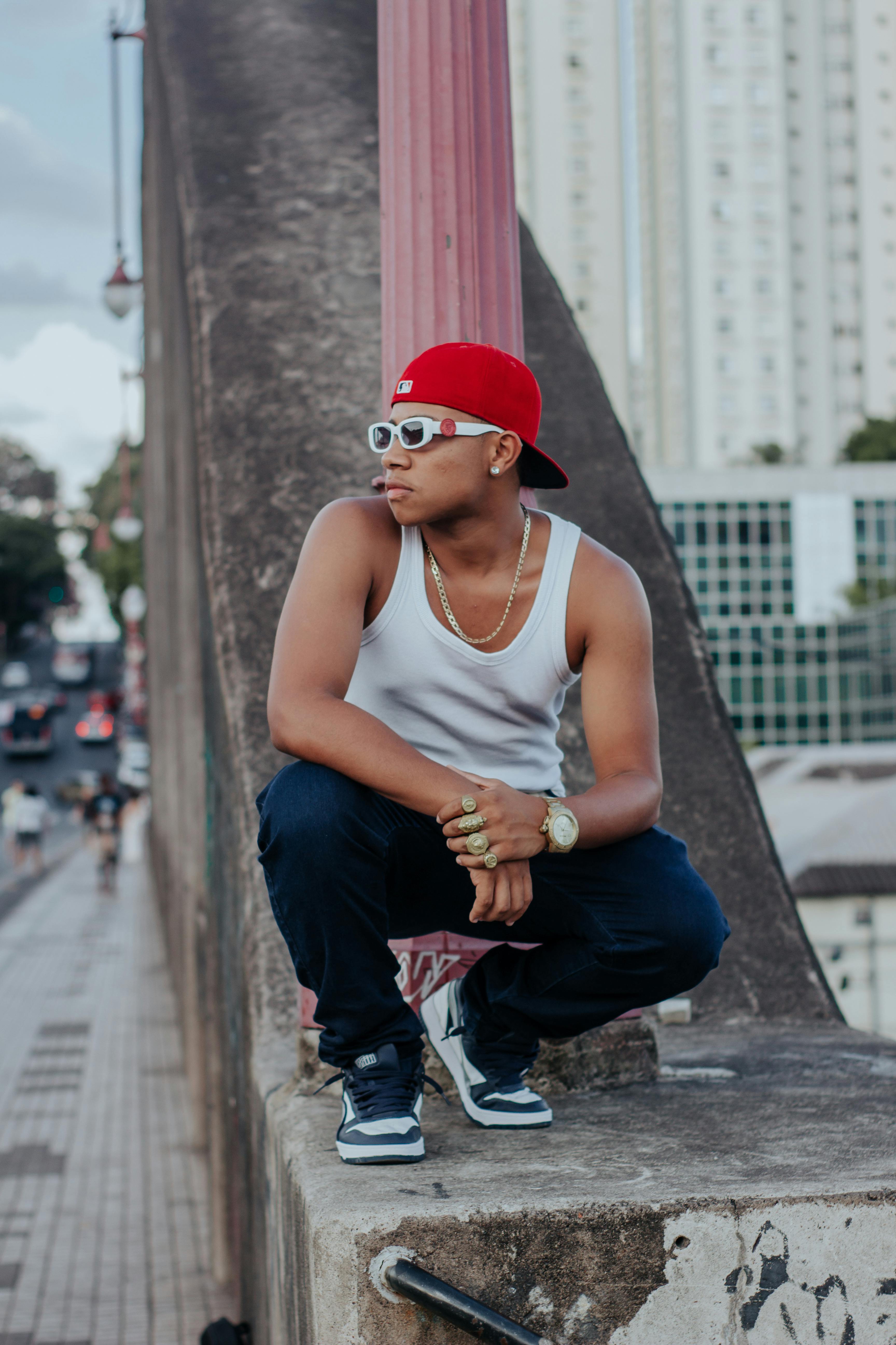 A Young Man in a Casual Outfit Crouching on a Wall in a City · Free ...