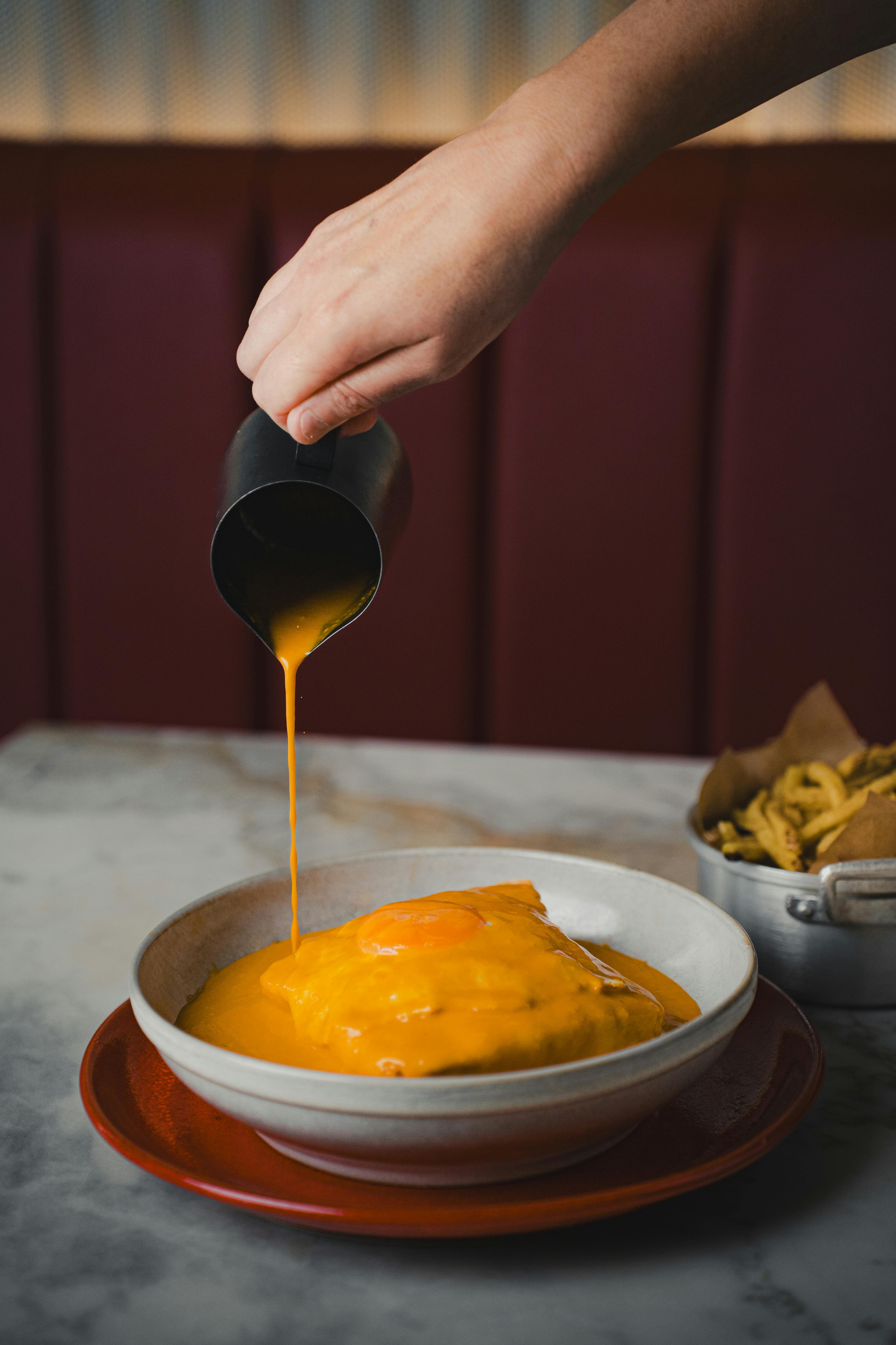 Person Hand Pouring Sauce to Food · Free Stock Photo