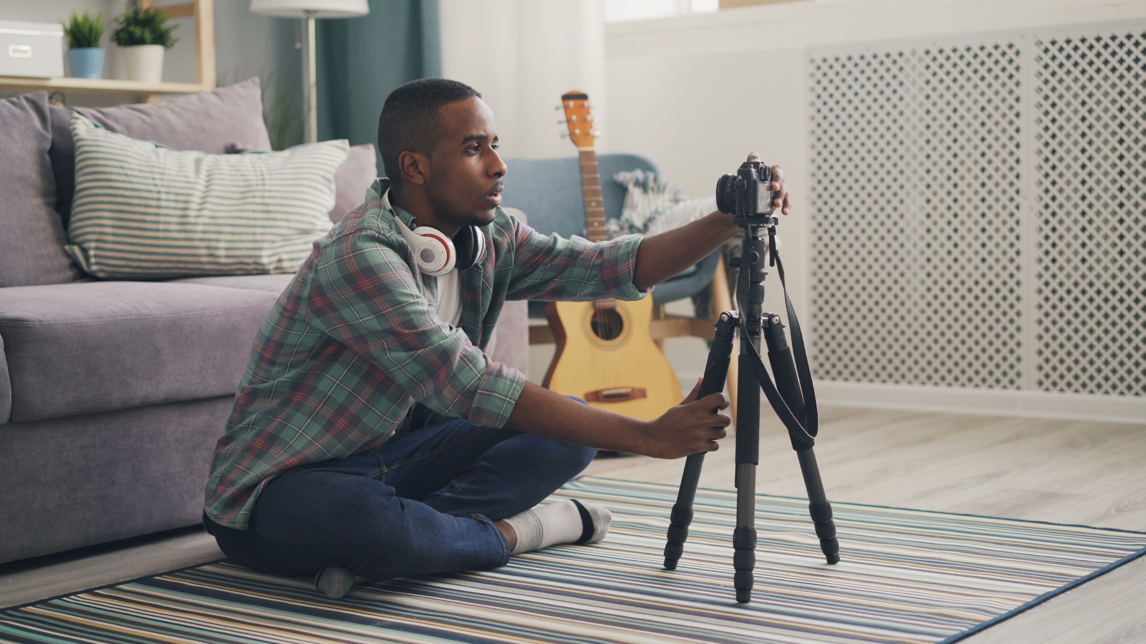 Man Sitting with Camera on Tripod · Free Stock Photo