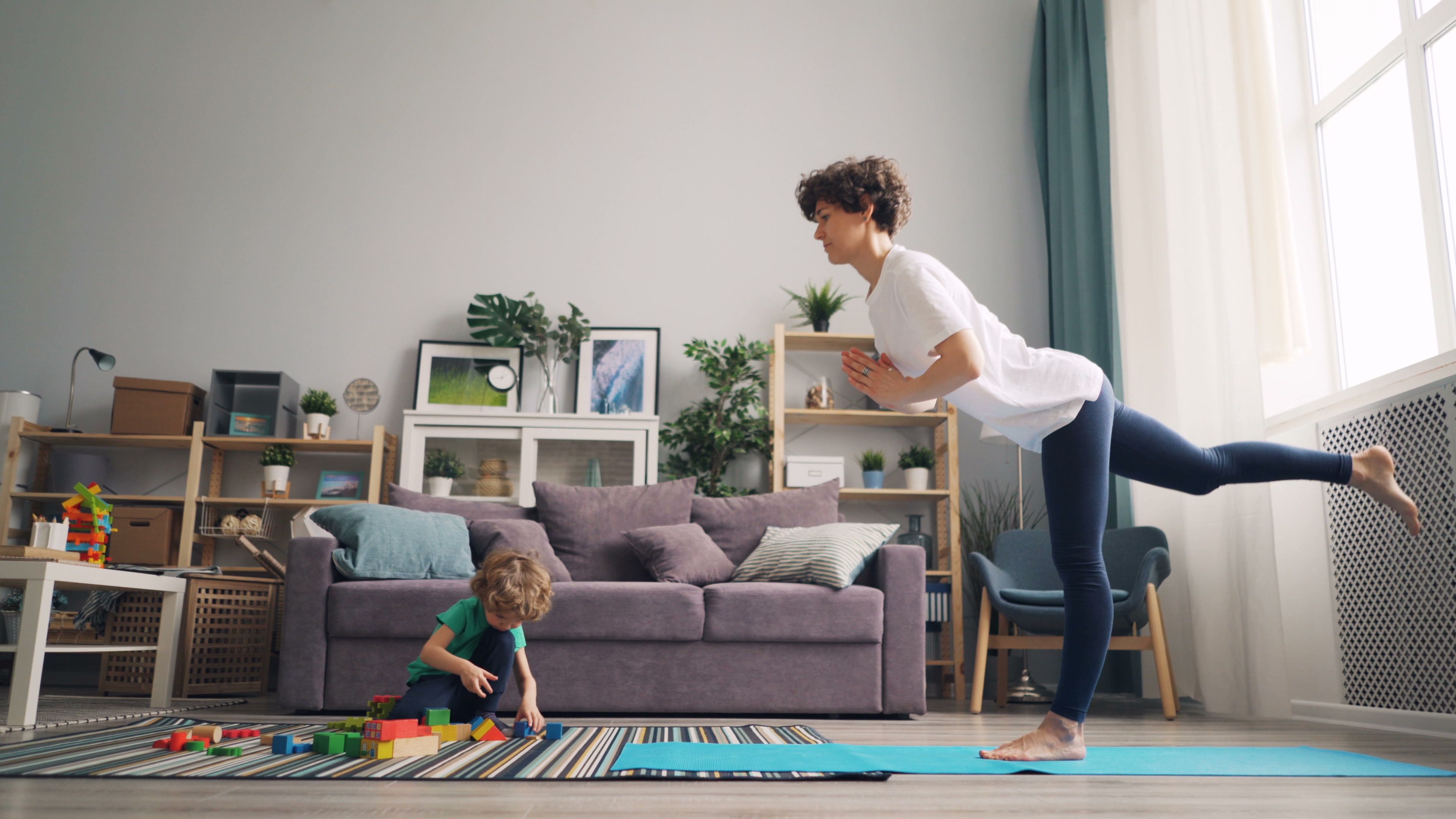 Mother Exercising and Son Playing on Carpet · Free Stock Photo