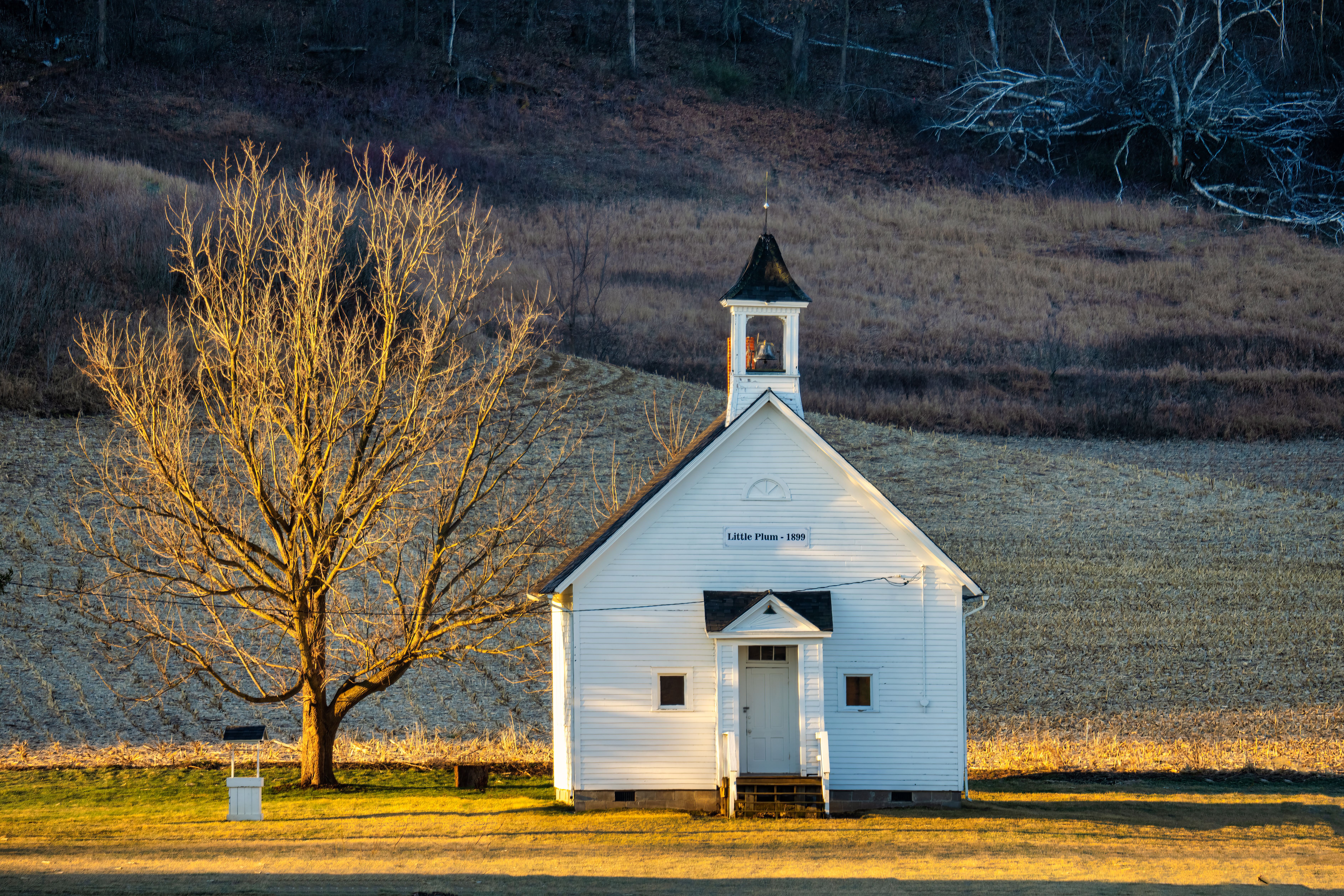 A small white church sits in the middle of a field · Free Stock Photo