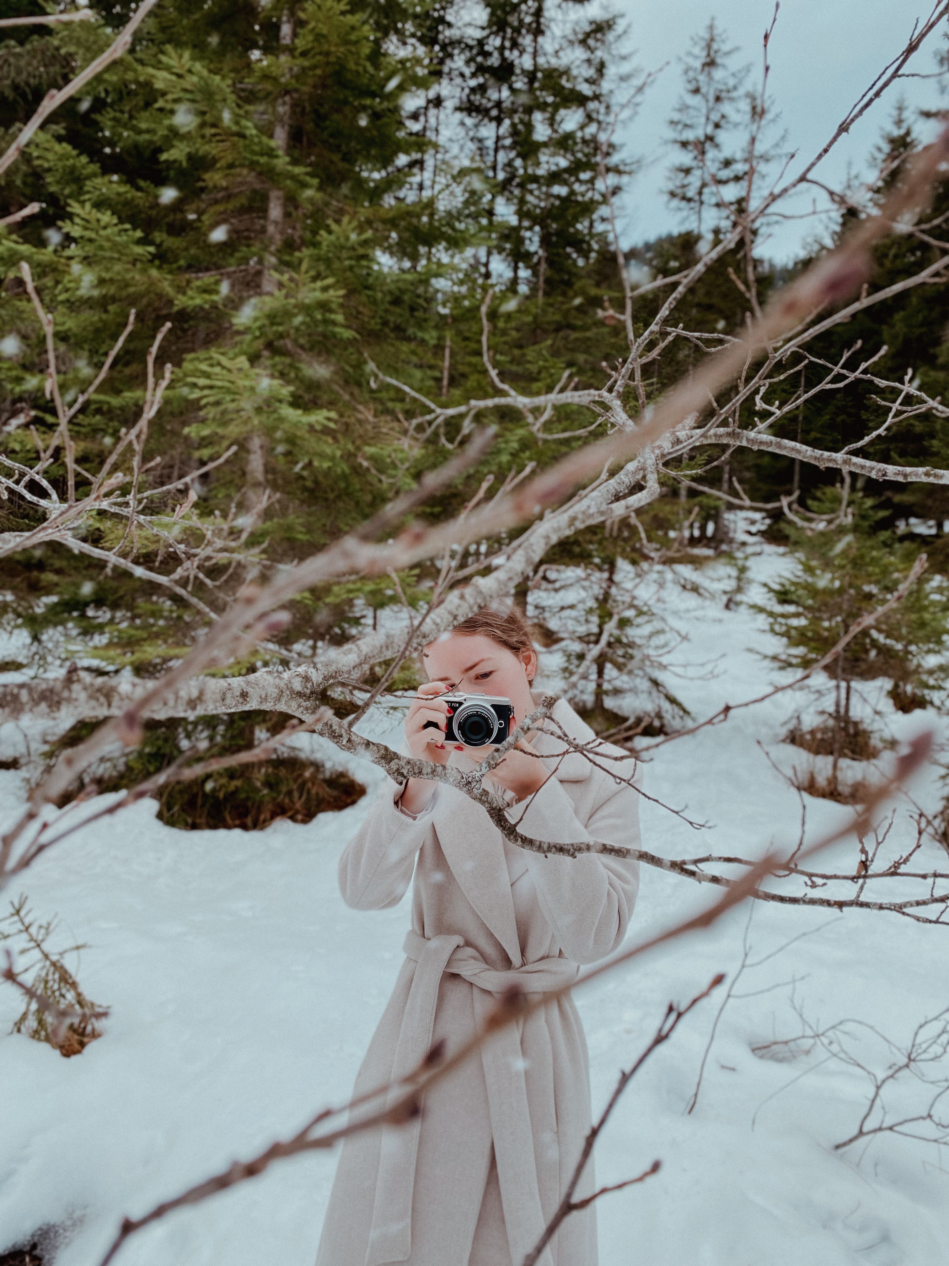 A Woman Taking Pictures with a Film Camera Outside in Winter · Free ...
