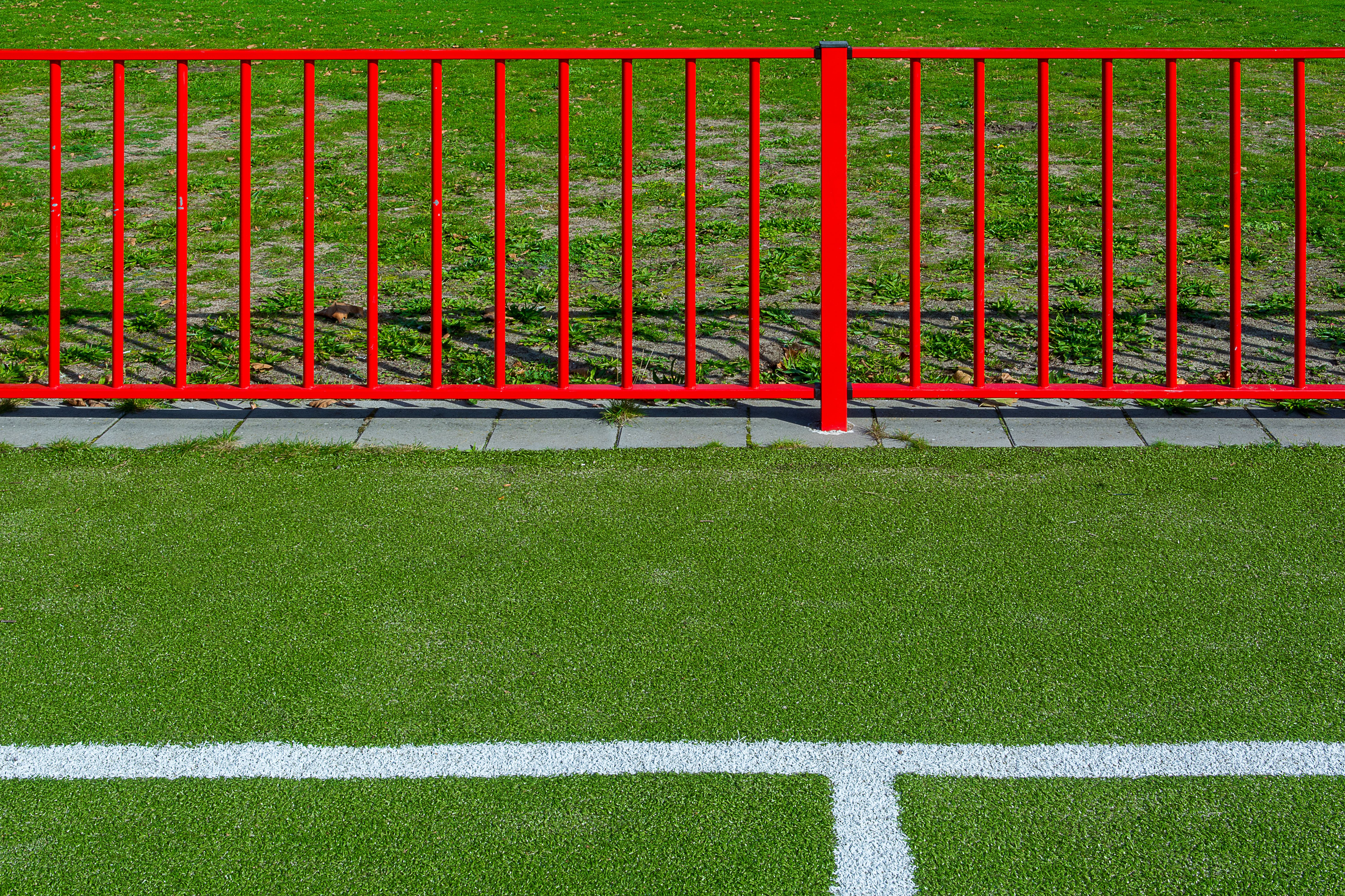 A red fence on a soccer field · Free Stock Photo