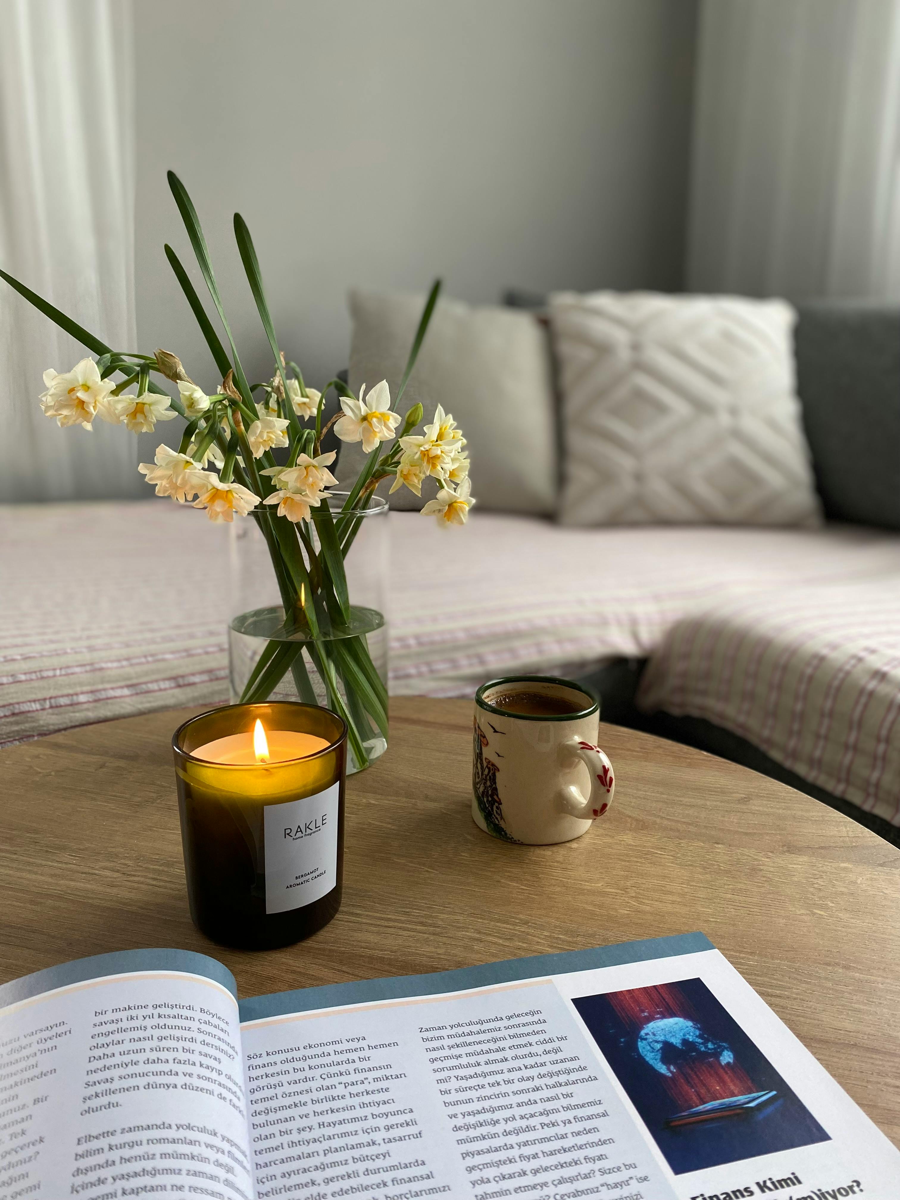An Open Magazine on the Coffee Table with Candle and Flowers · Free ...