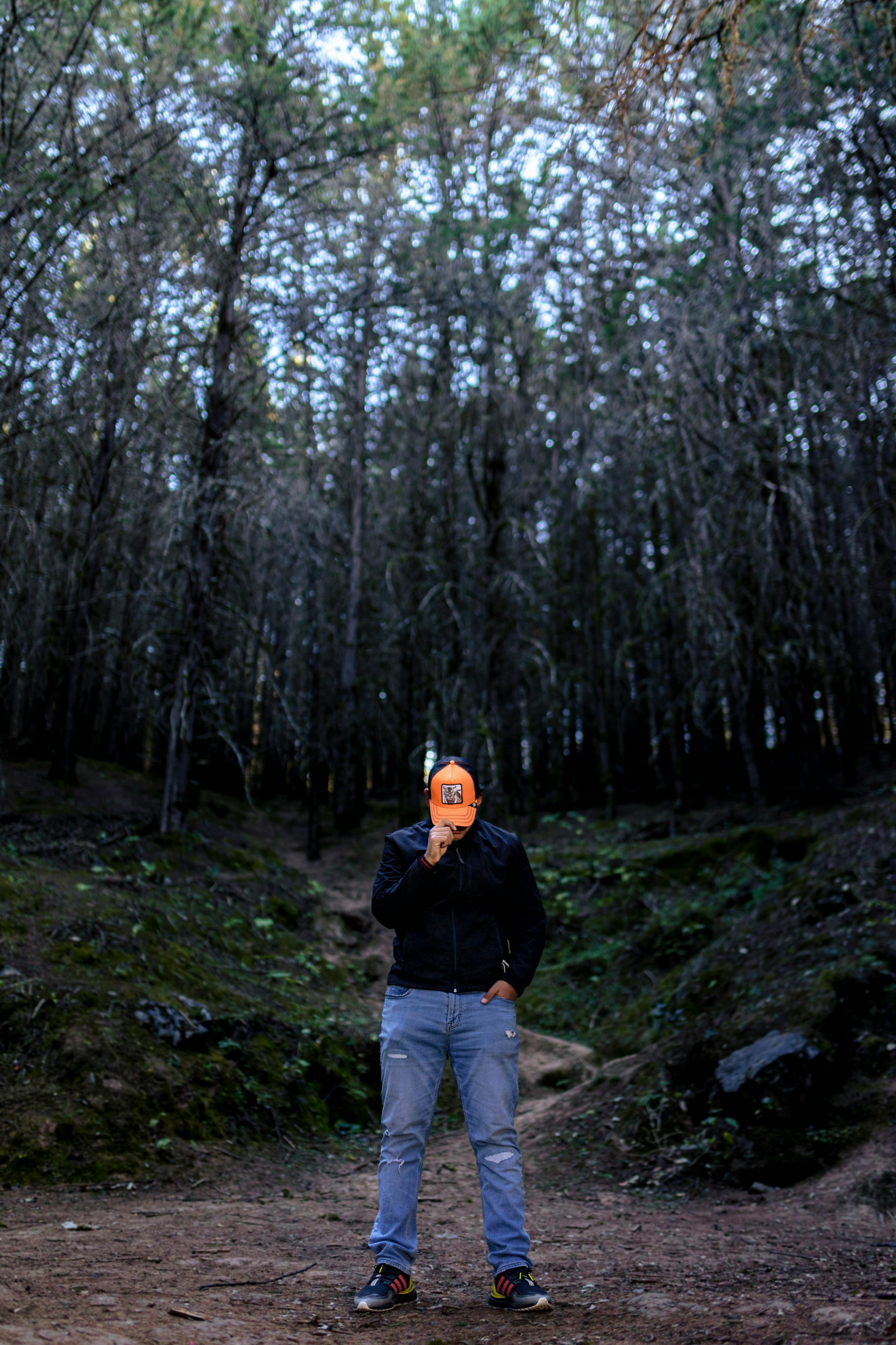 A man standing in the woods with a phone in his hand · Free Stock Photo