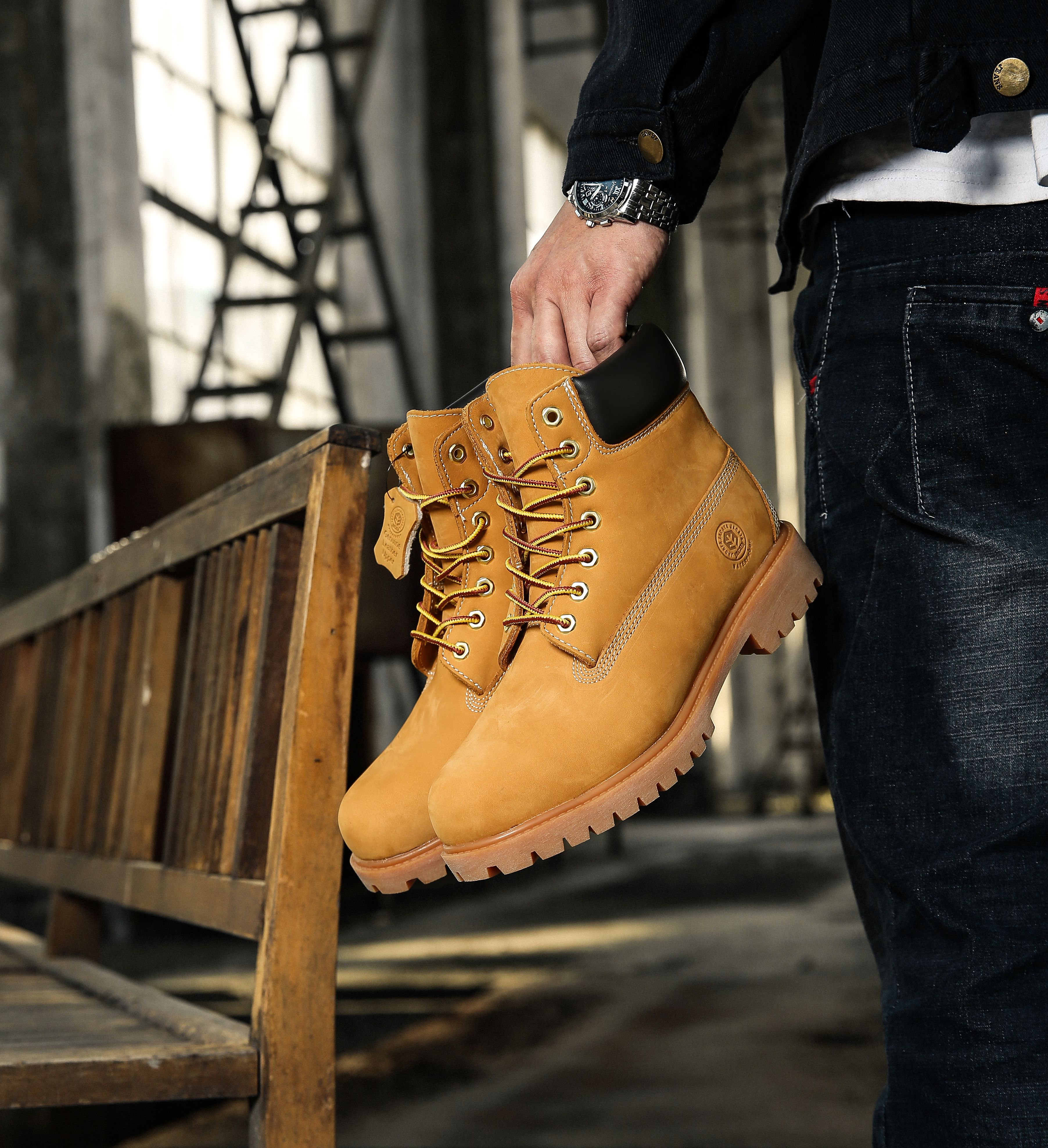 Hand of a Man Holding a Pair of Brown Hiking Boots · Free Stock Photo