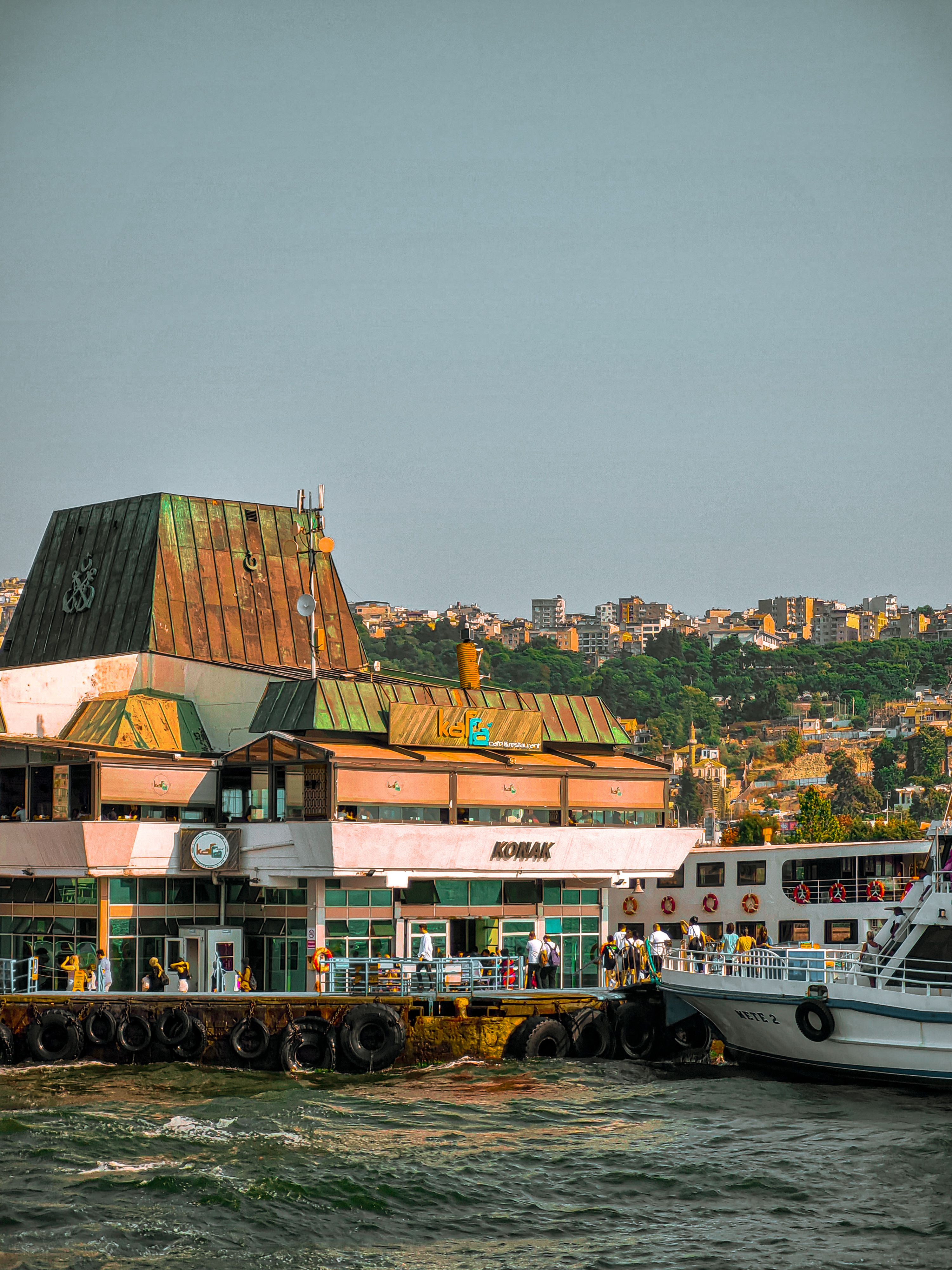 A boat is docked in front of a building · Free Stock Photo