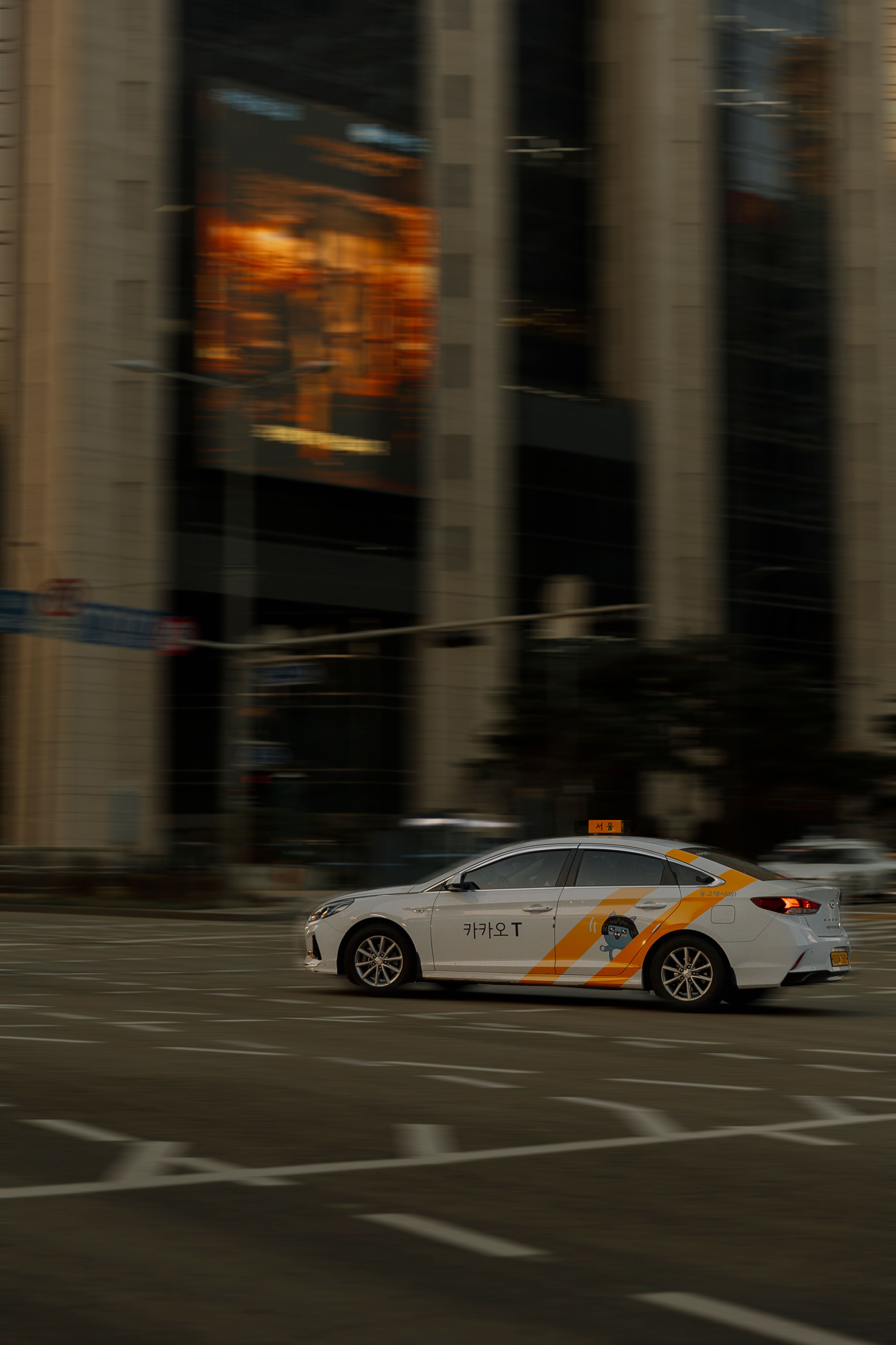 A taxi driving down a city street · Free Stock Photo
