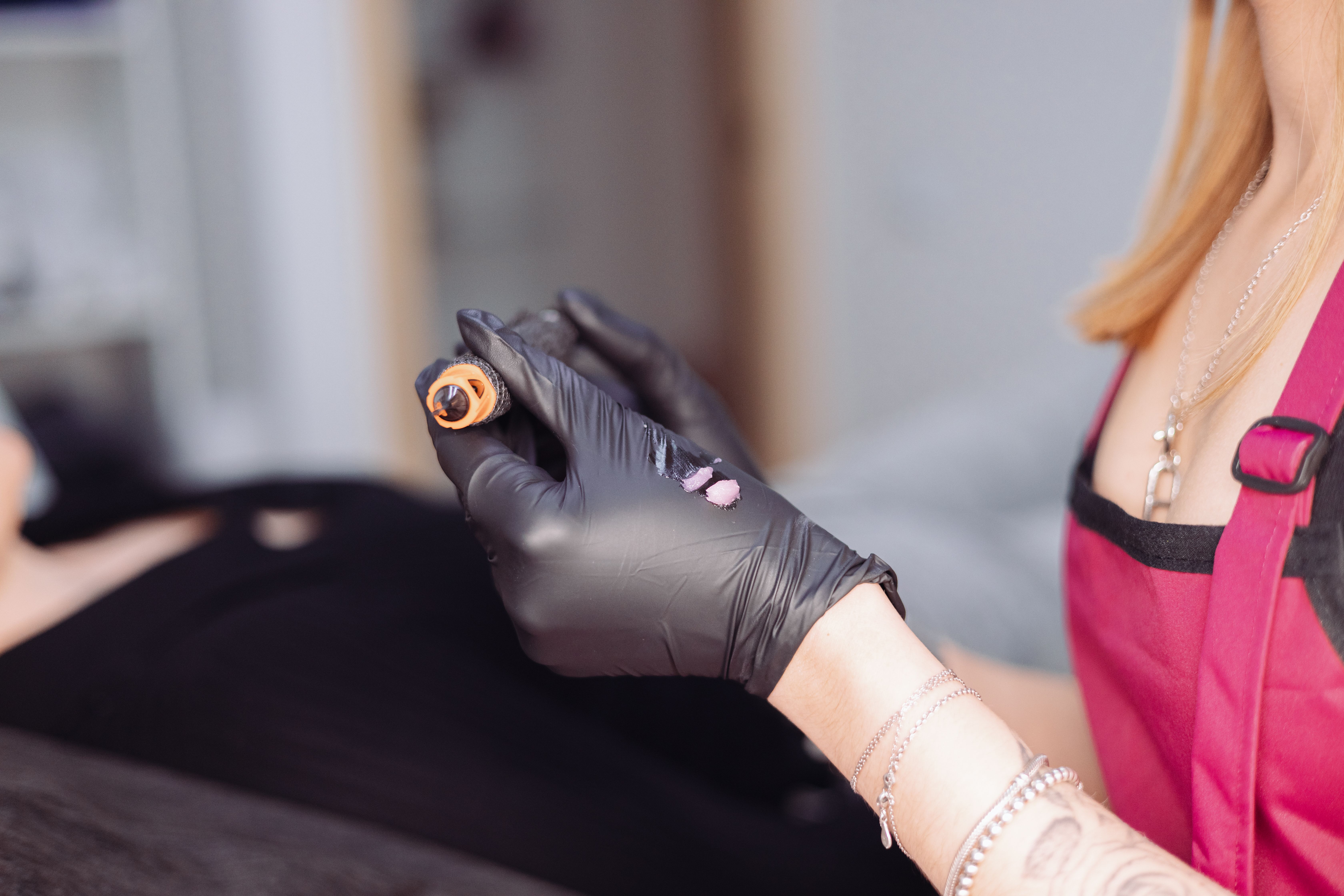 A woman getting a tattoo on her arm · Free Stock Photo