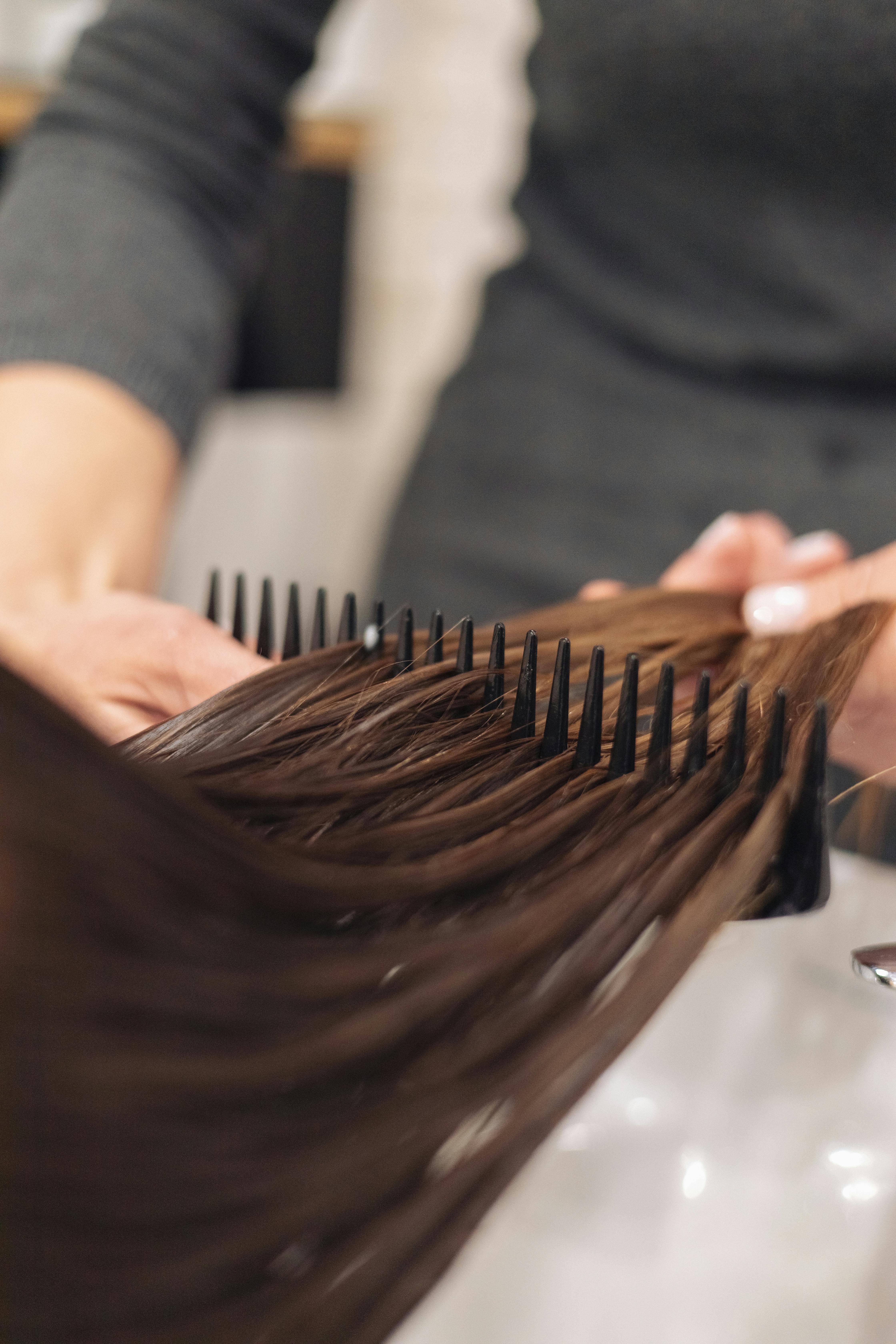 A Hairdresser Combing Clients Hair · Free Stock Photo
