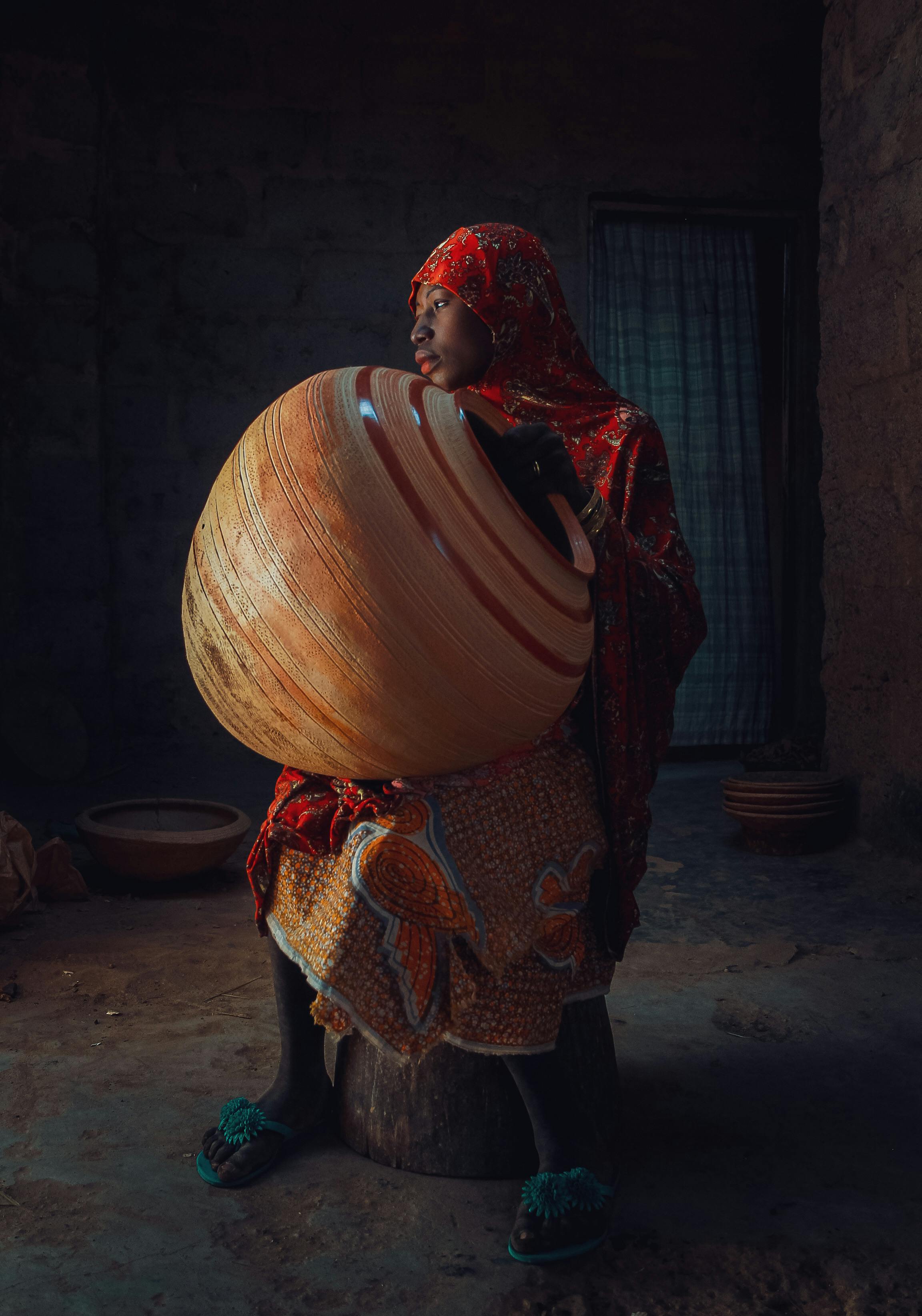 African Woman in Traditional Clothing Sitting and Holding a Calabash ...