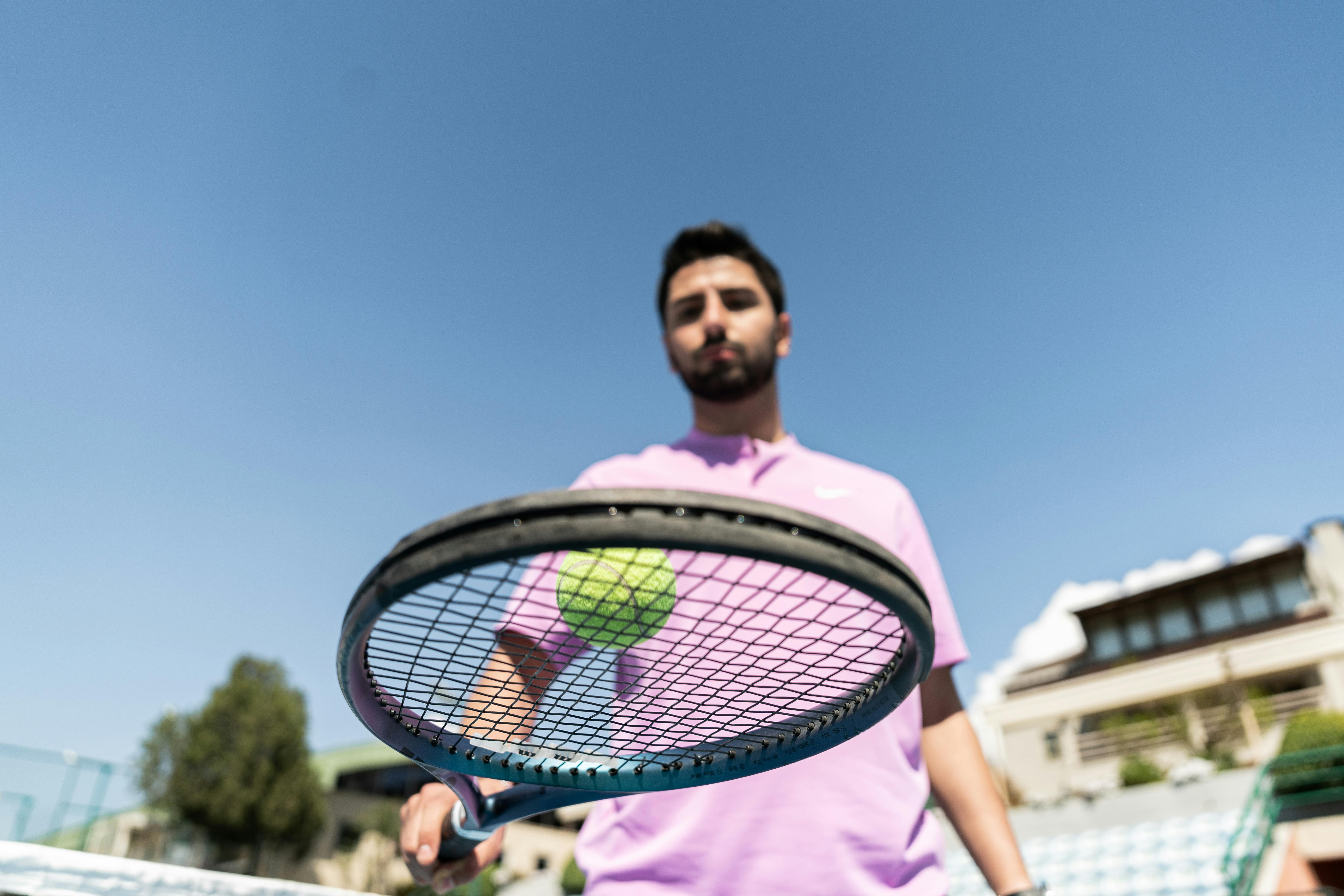 A Tennis Ball Bouncing Off a Tennis Racket · Free Stock Photo