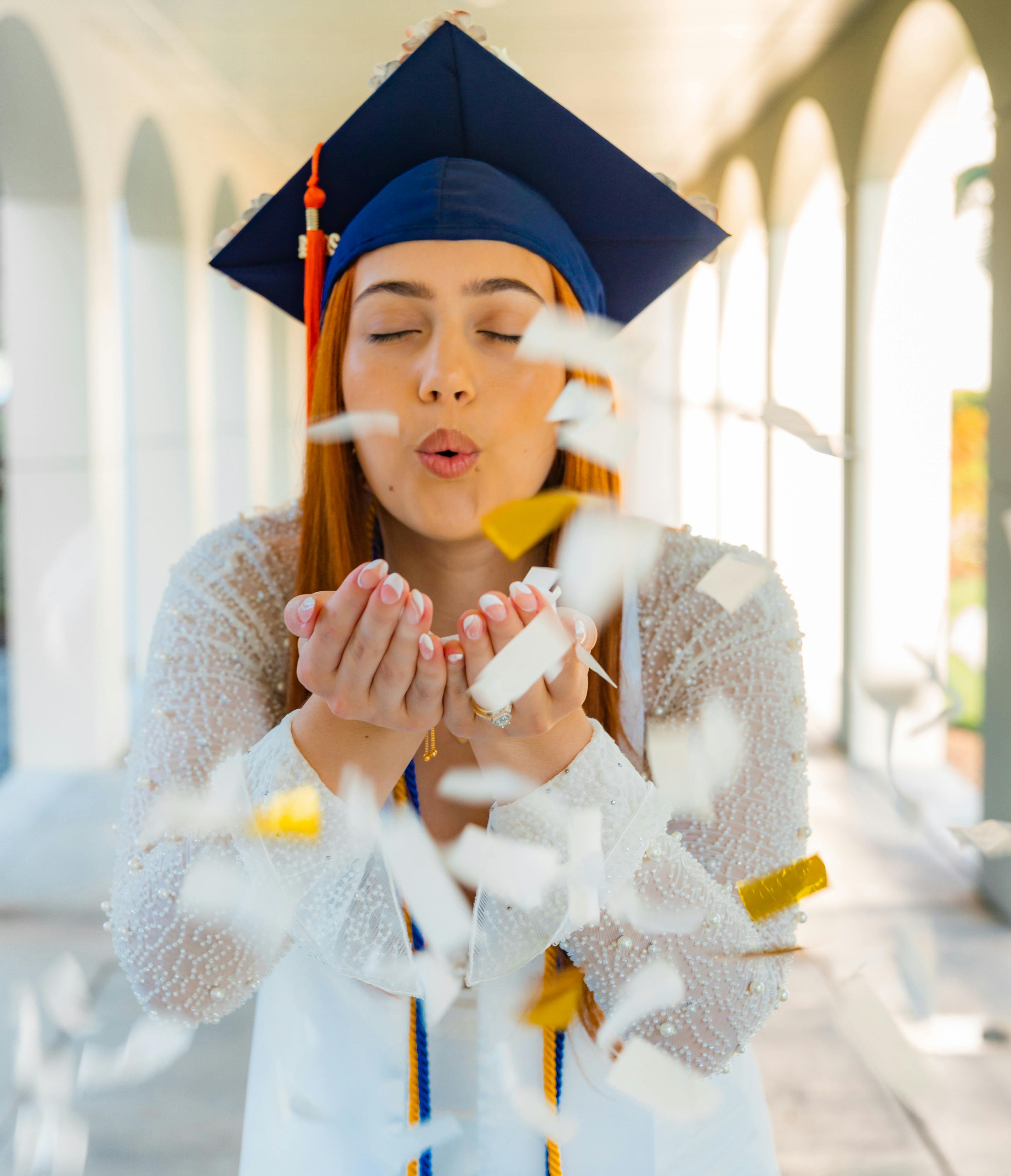 Woman in Academic Hat Blowing Confetti · Free Stock Photo