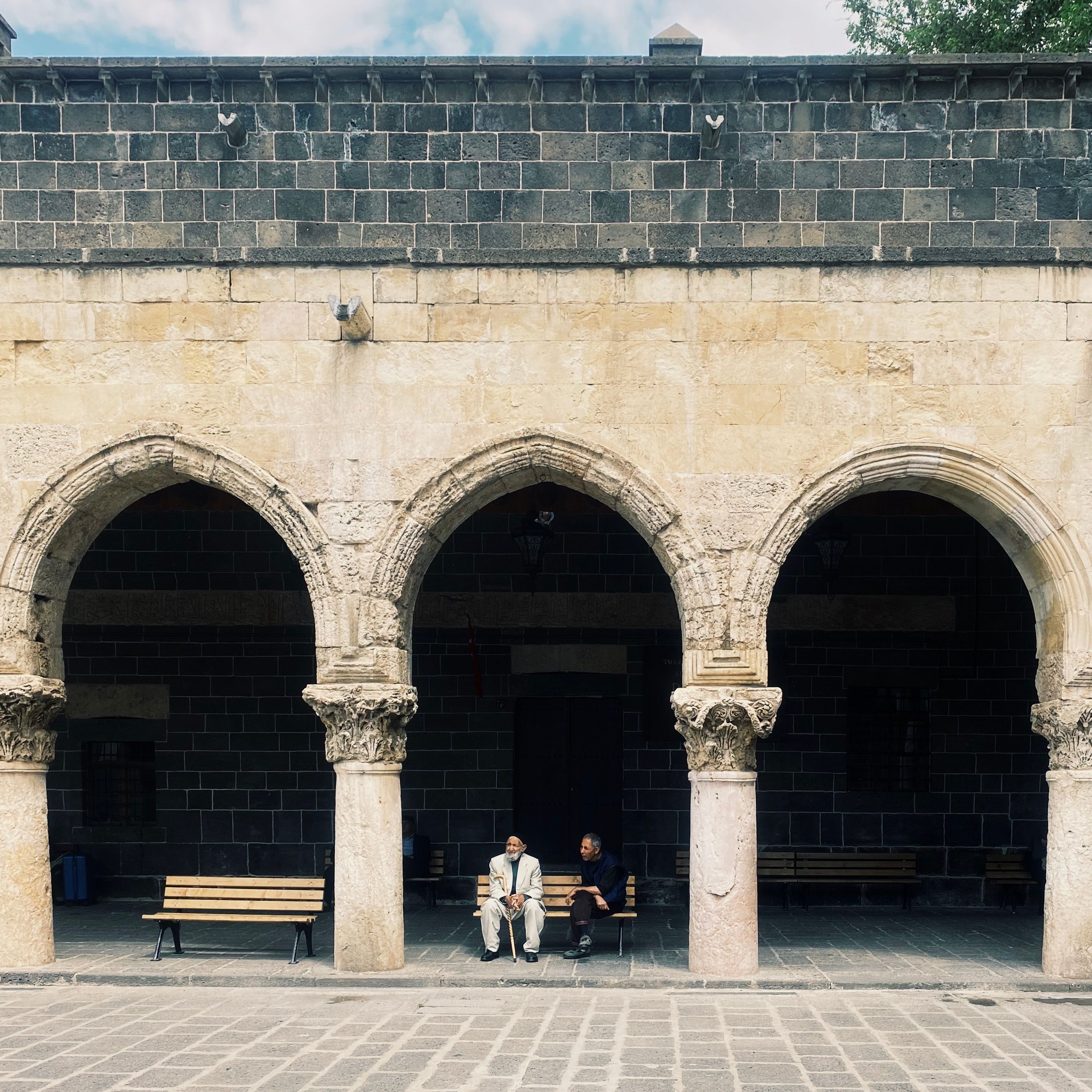 Men Sitting under Building Arches and Columns · Free Stock Photo