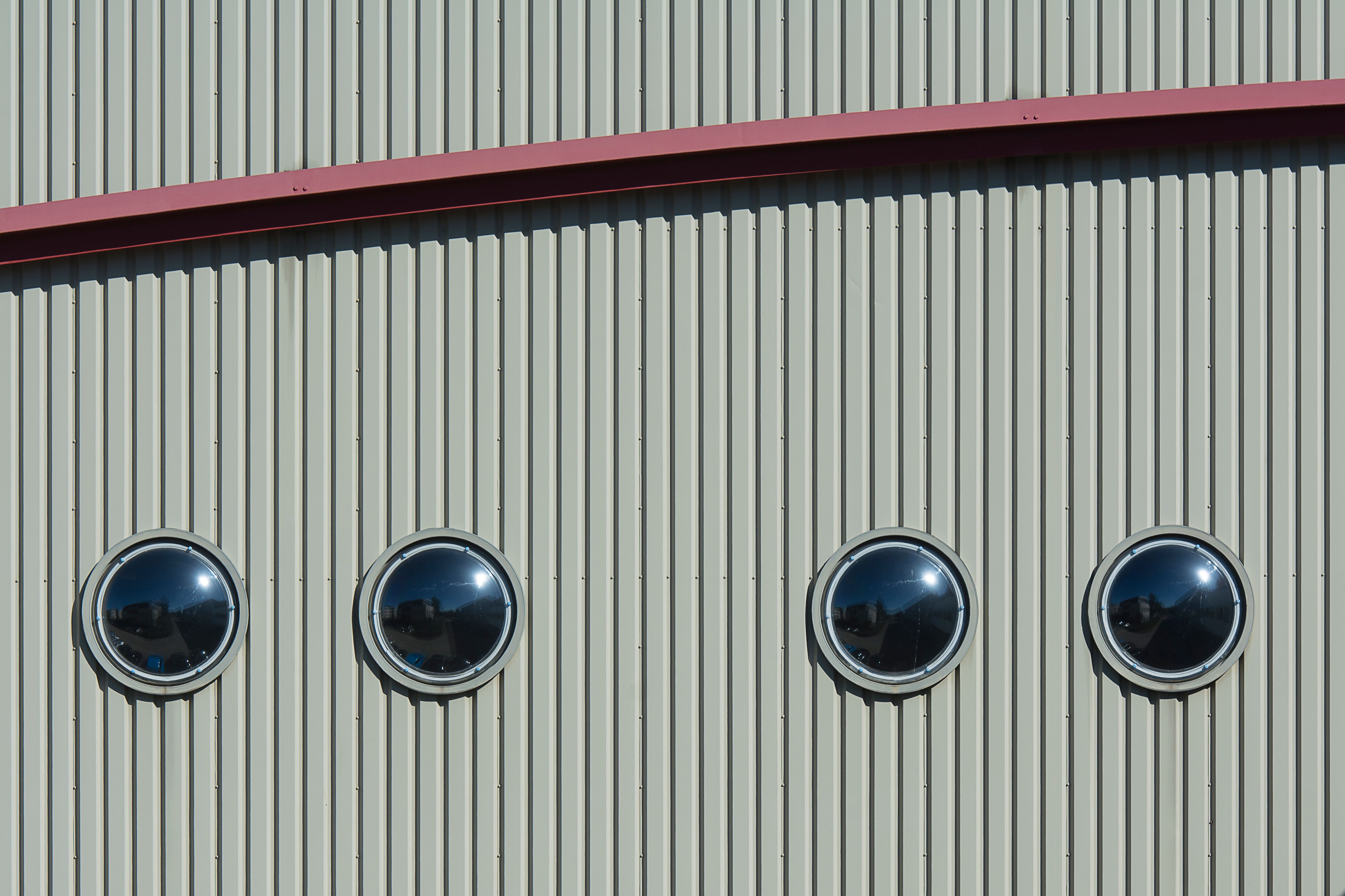 Three round windows on a metal building · Free Stock Photo