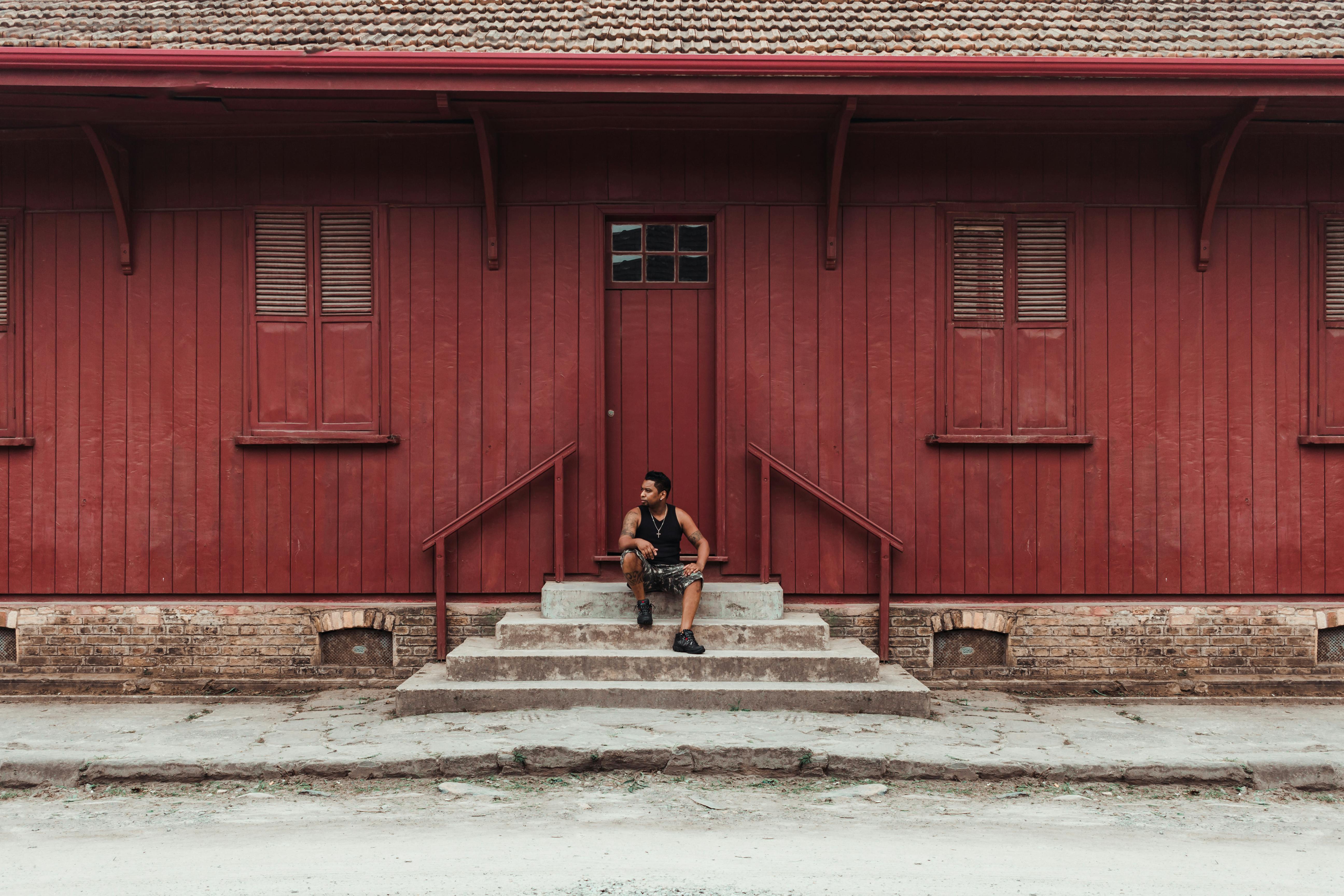 Man Sitting On A Stairway near a door · Free Stock Photo