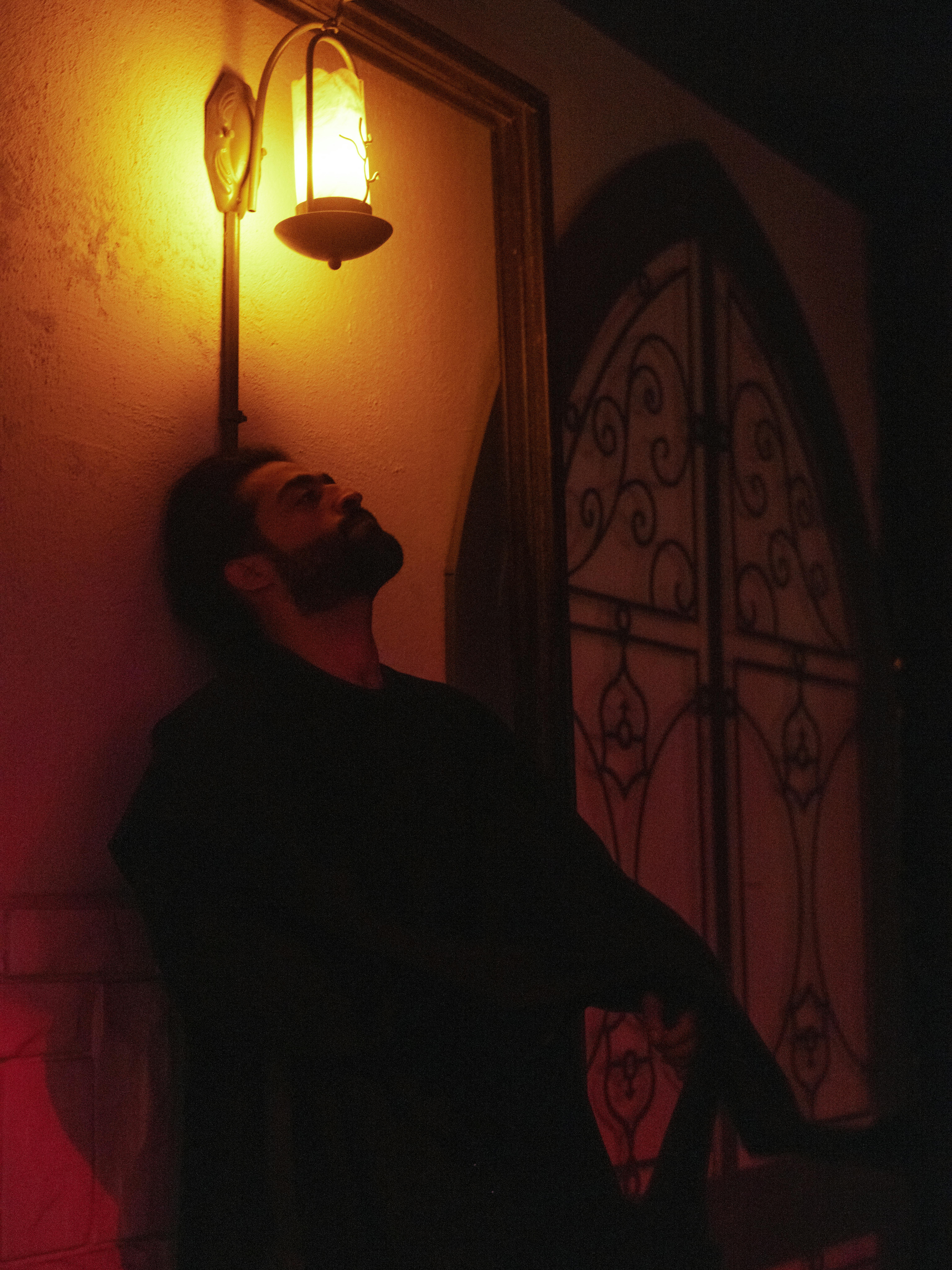 Man Leaning on a Wall Under the Lamp · Free Stock Photo