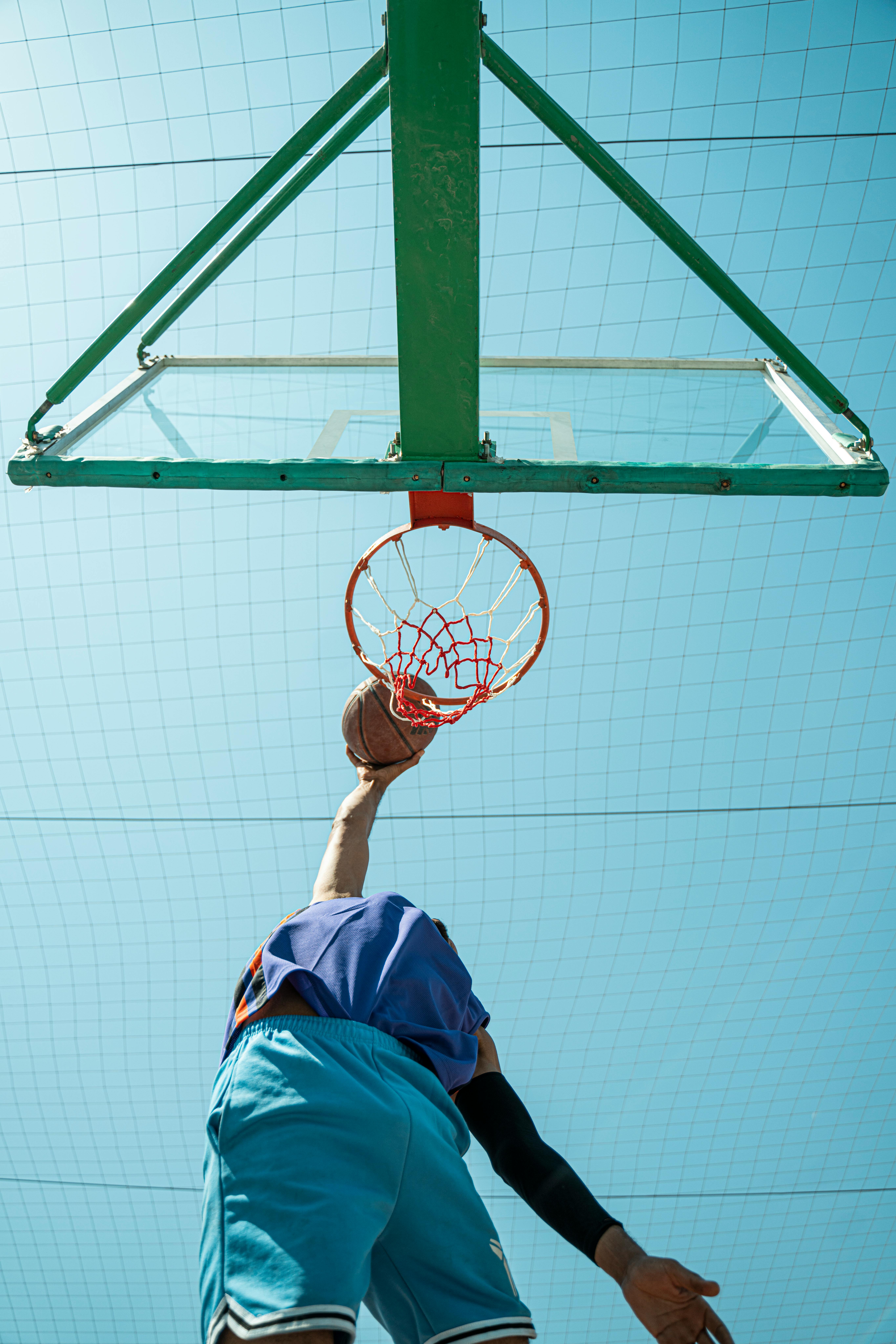 Low Angle Shot of a Man Jumping and Shooting the Ball into the Hoop ...