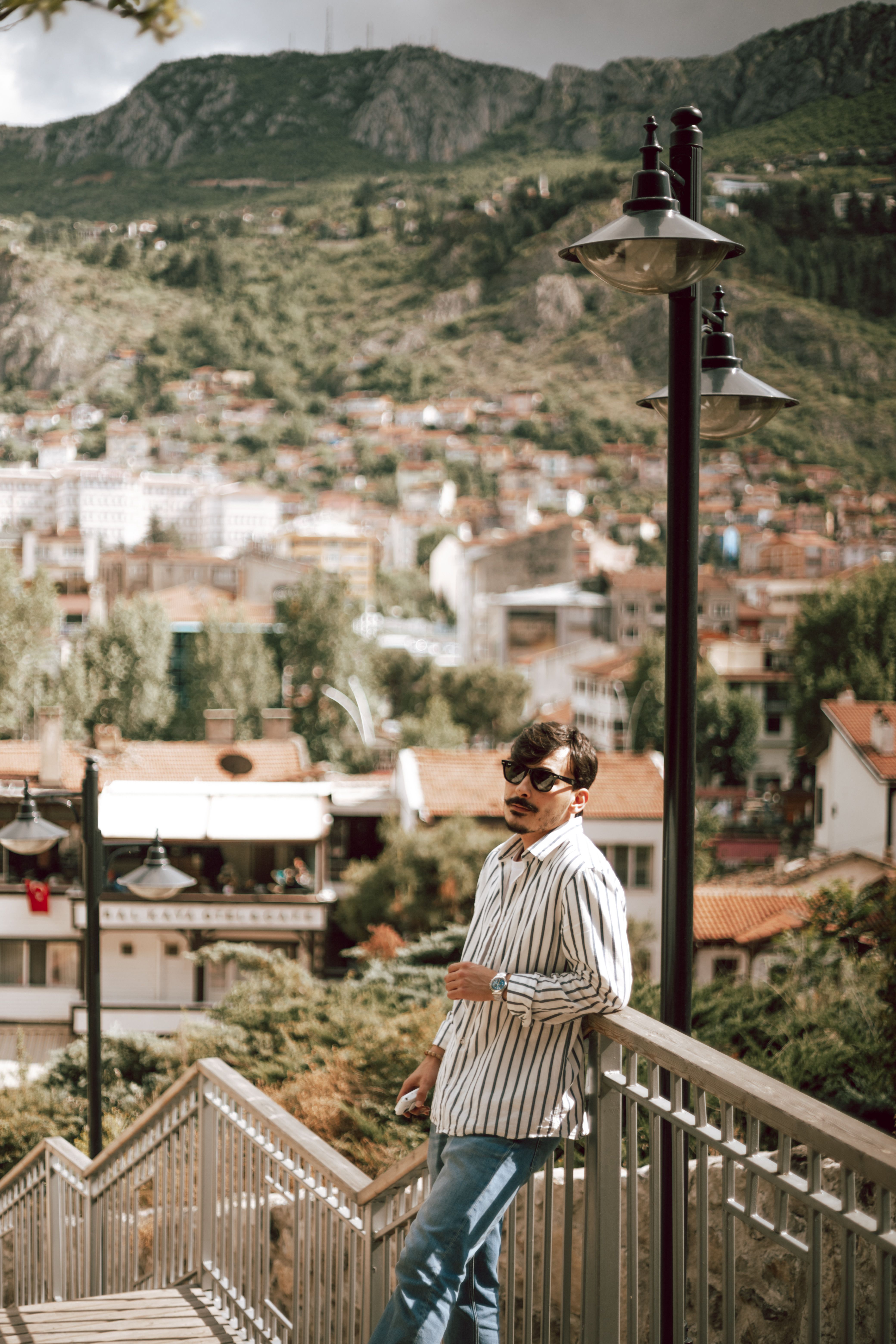 Man in Shirt Leaning on Railing in Town · Free Stock Photo