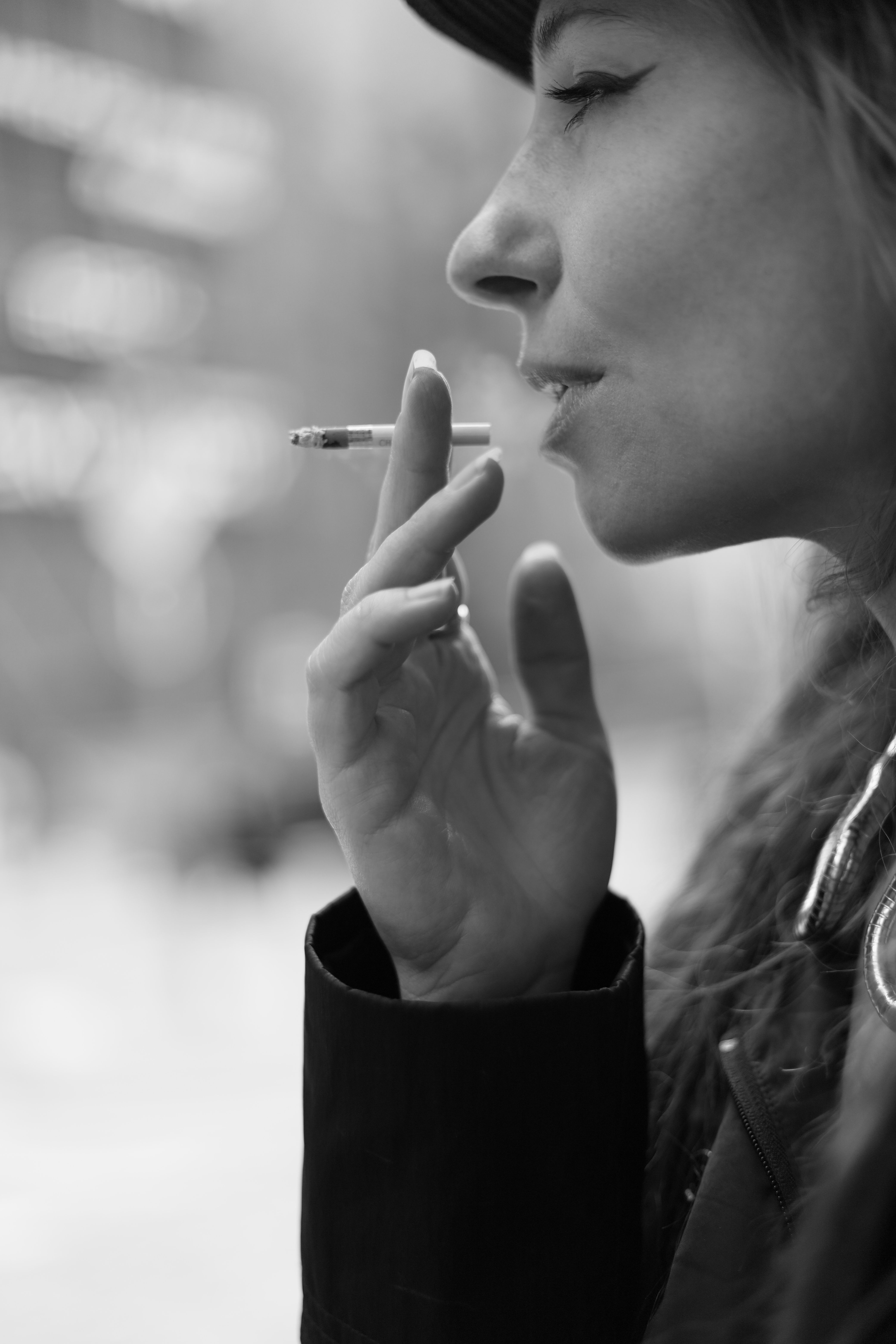 A woman smoking a cigarette in black and white · Free Stock Photo