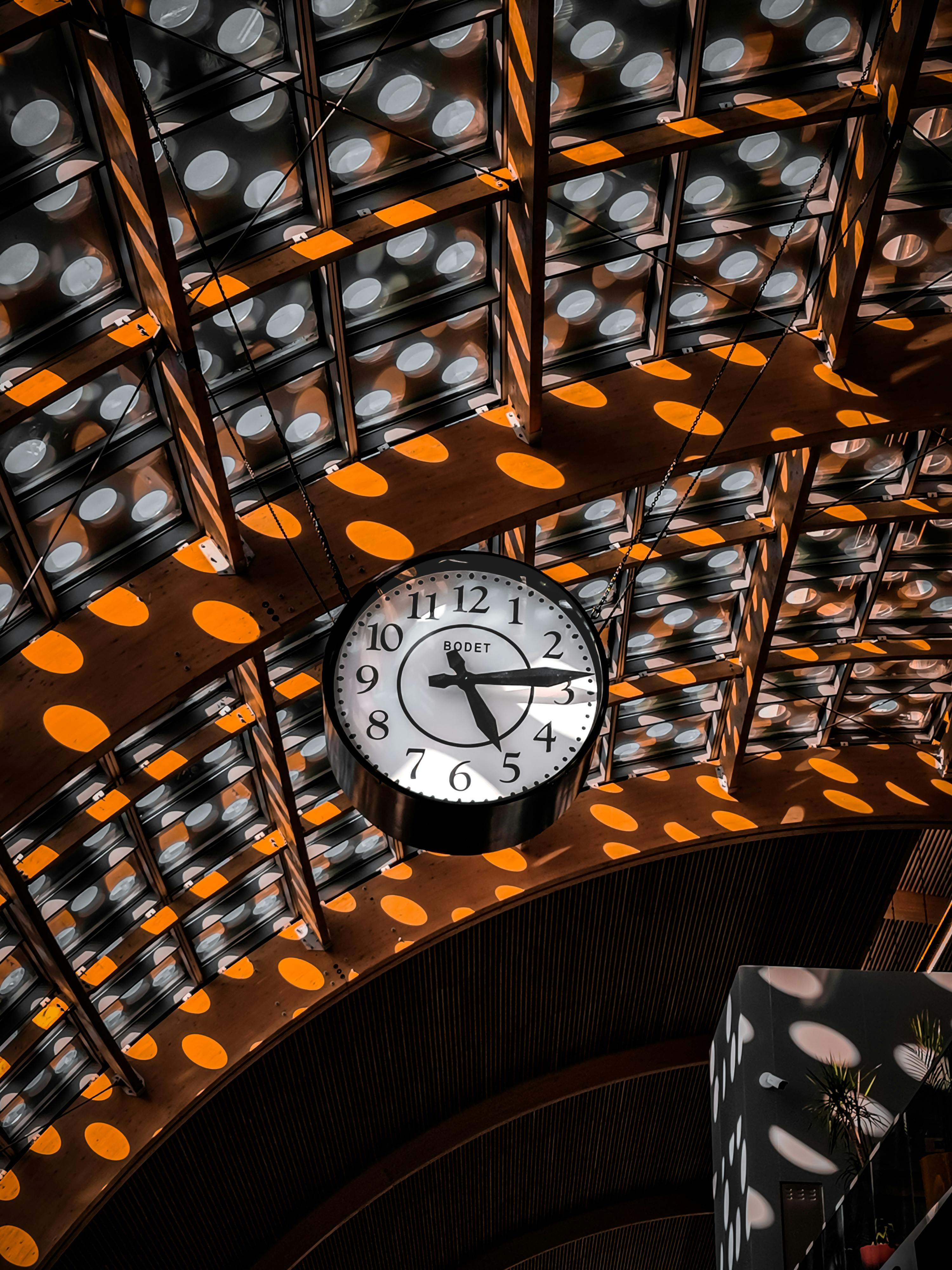 Clock Hanging From Ceiling of Modern Building · Free Stock Photo