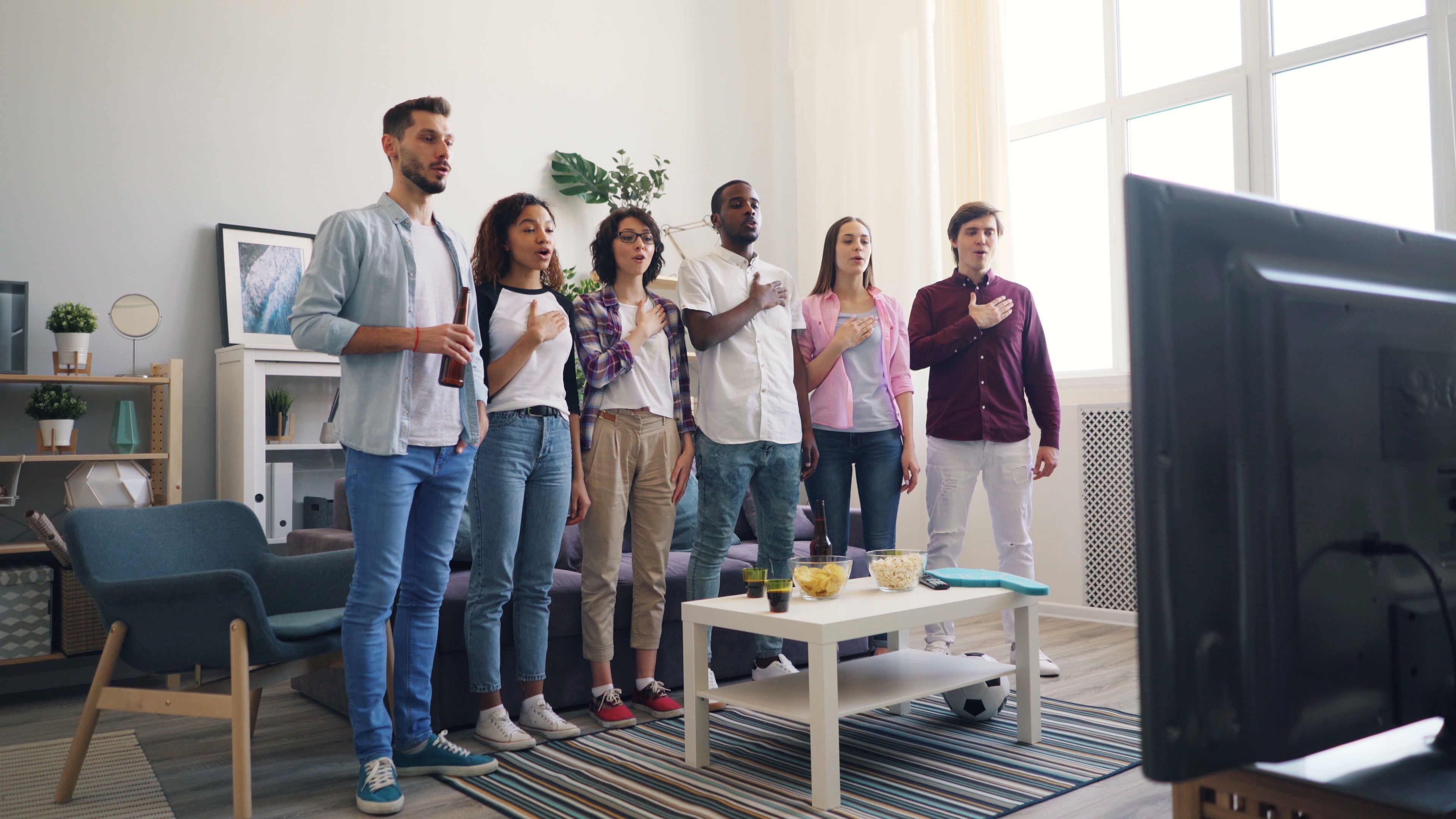 Group of friends watching tv in living room · Free Stock Photo