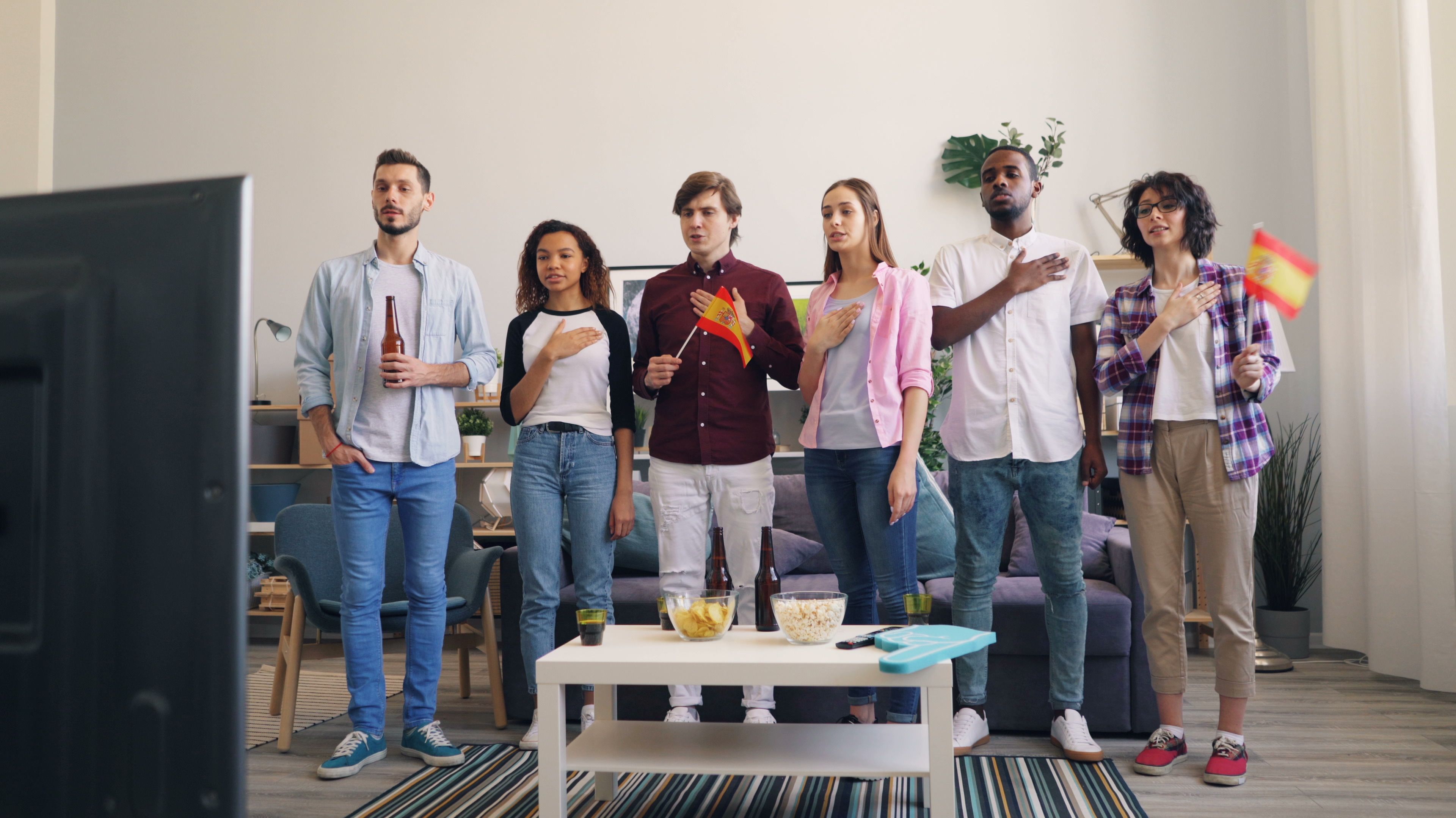A group of people standing in front of a television · Free Stock Photo
