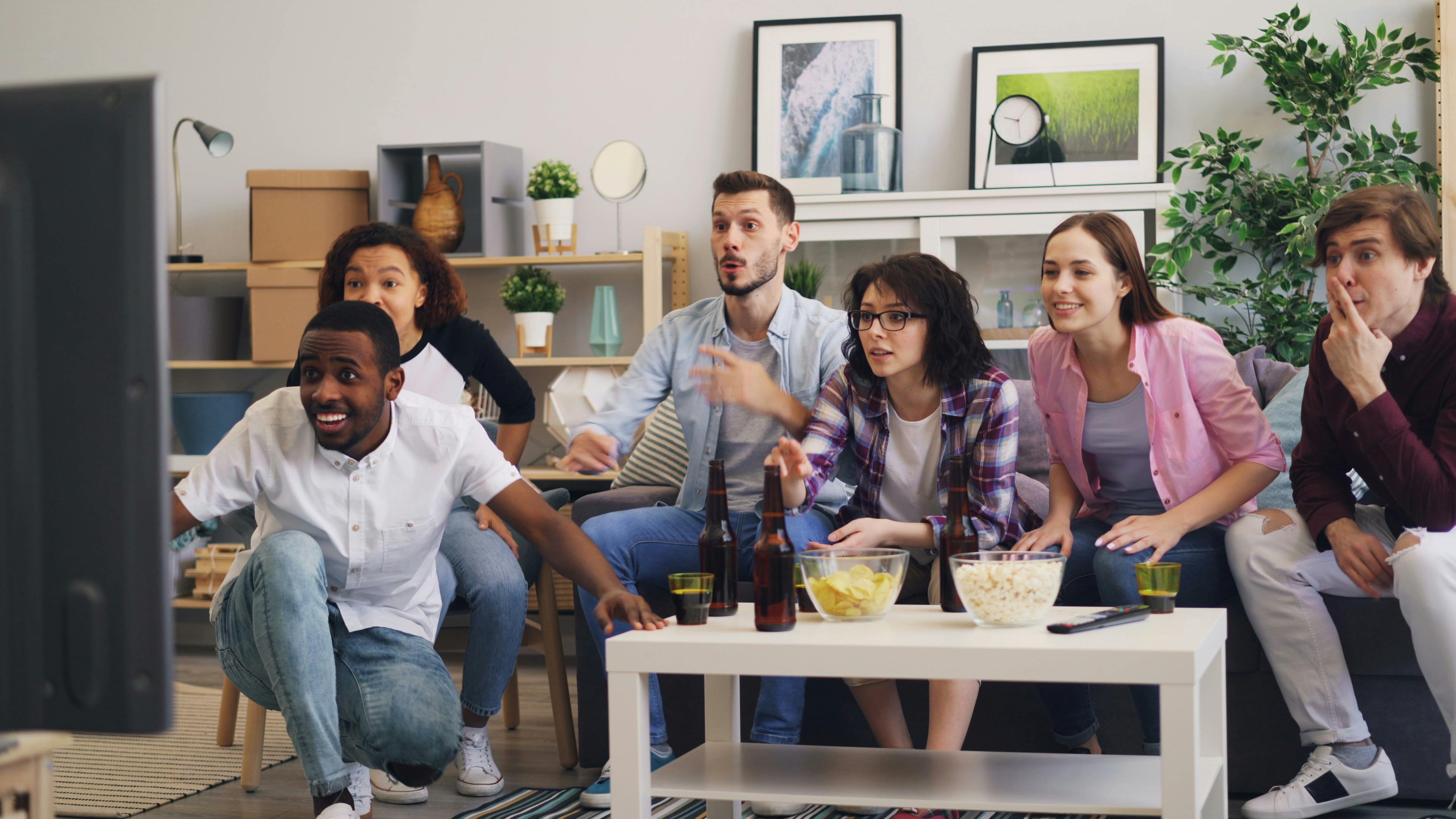 Group of friends watching tv in living room · Free Stock Photo