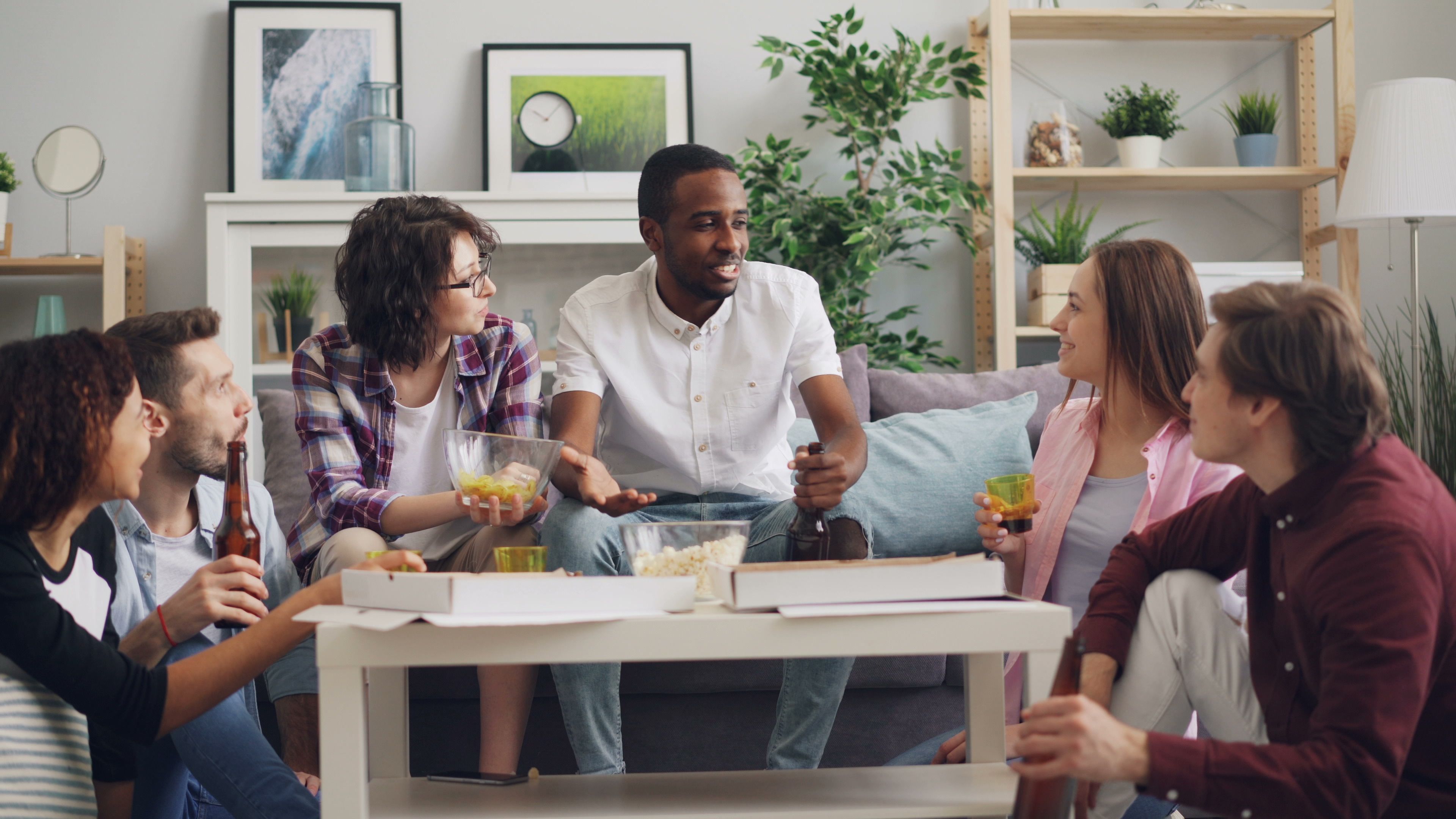 A group of people sitting around a table in a living room · Free Stock ...