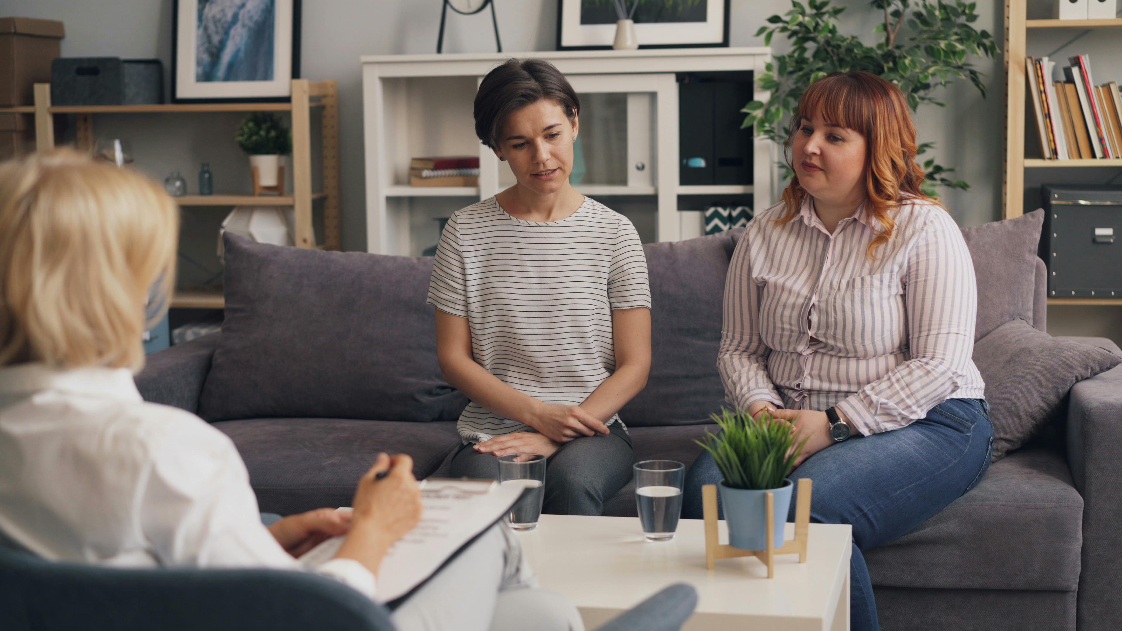 Three women sitting on a couch talking to each other · Free Stock Photo