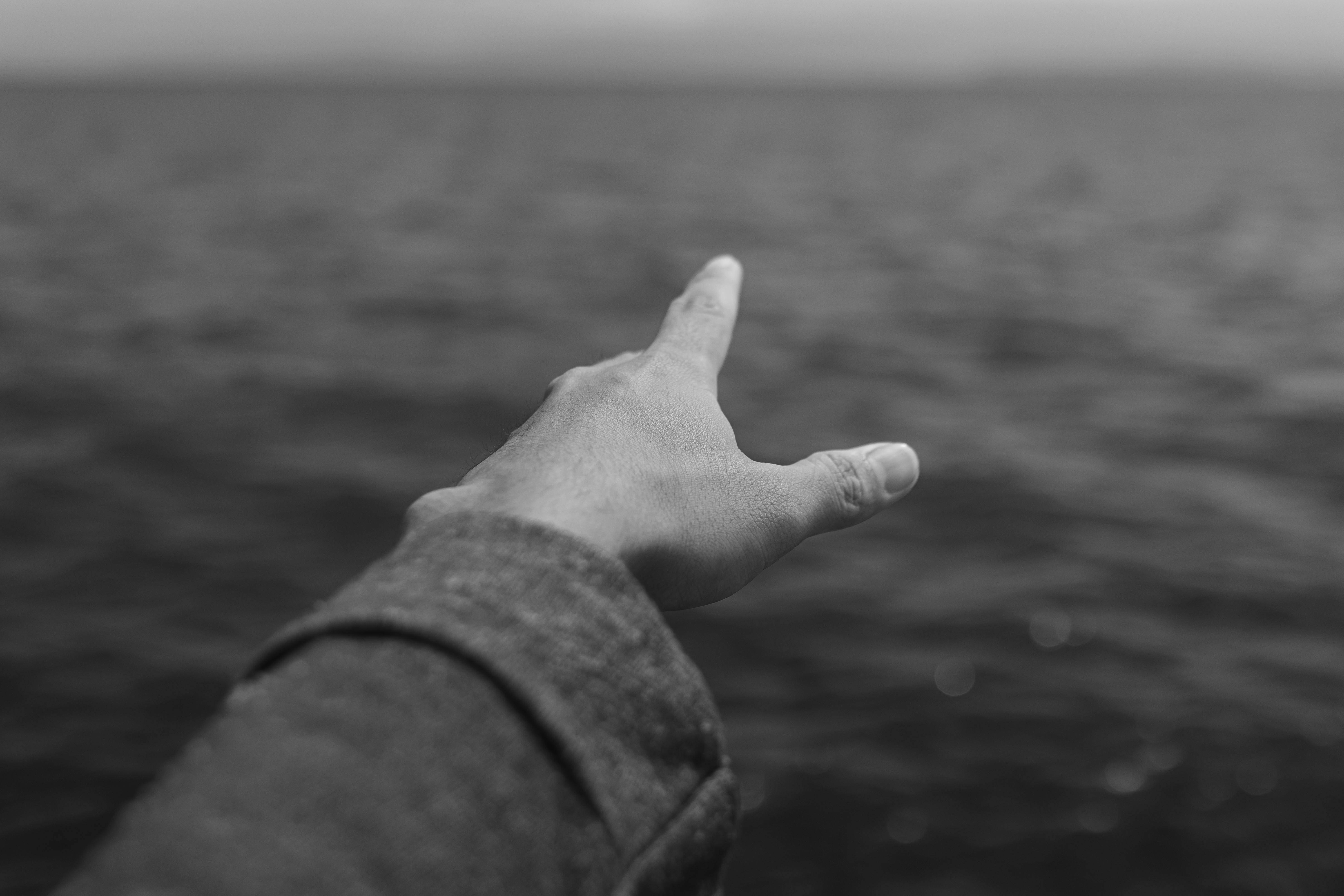 Man Holding Hand over Sea · Free Stock Photo