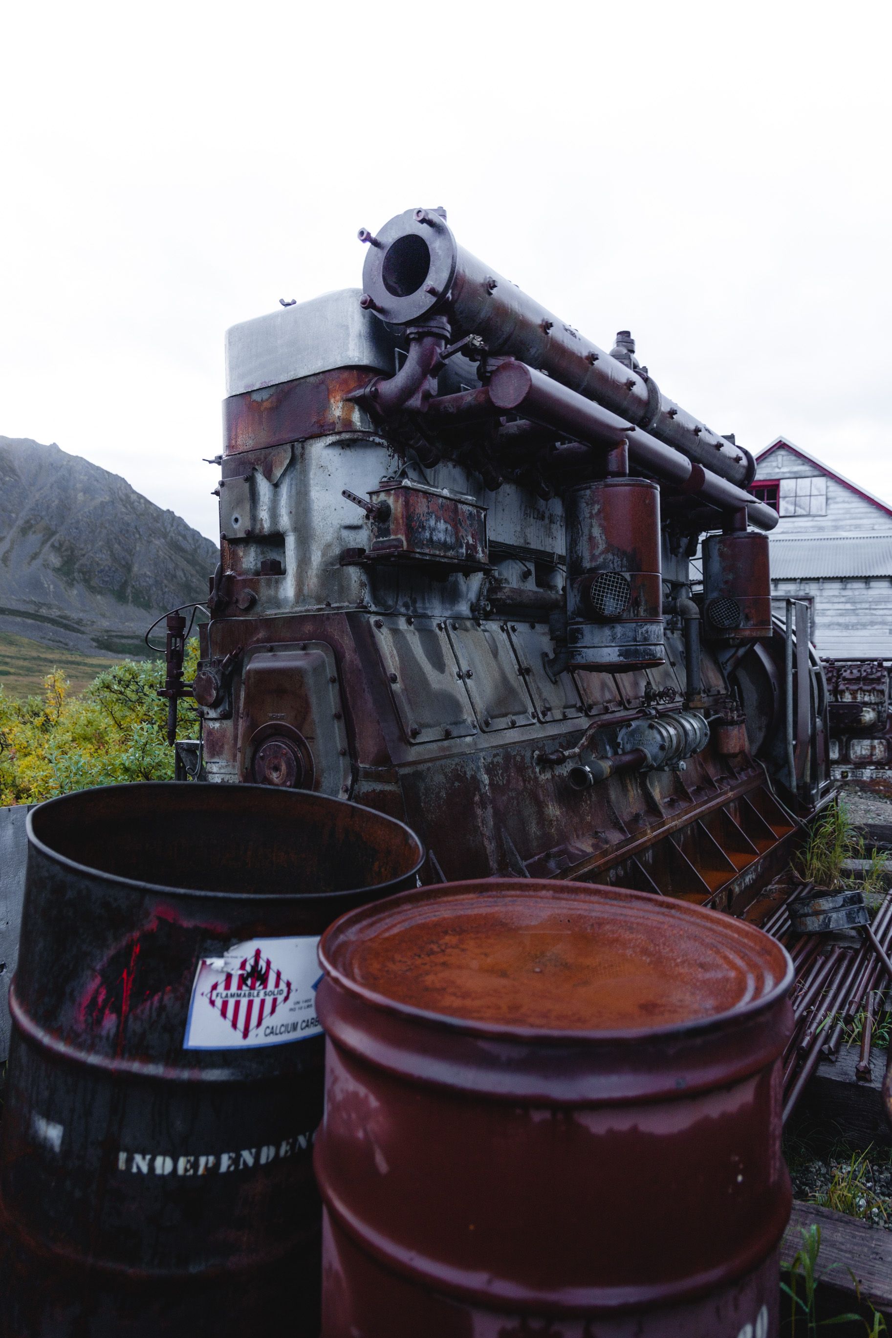An old rusty engine sitting next to barrels · Free Stock Photo
