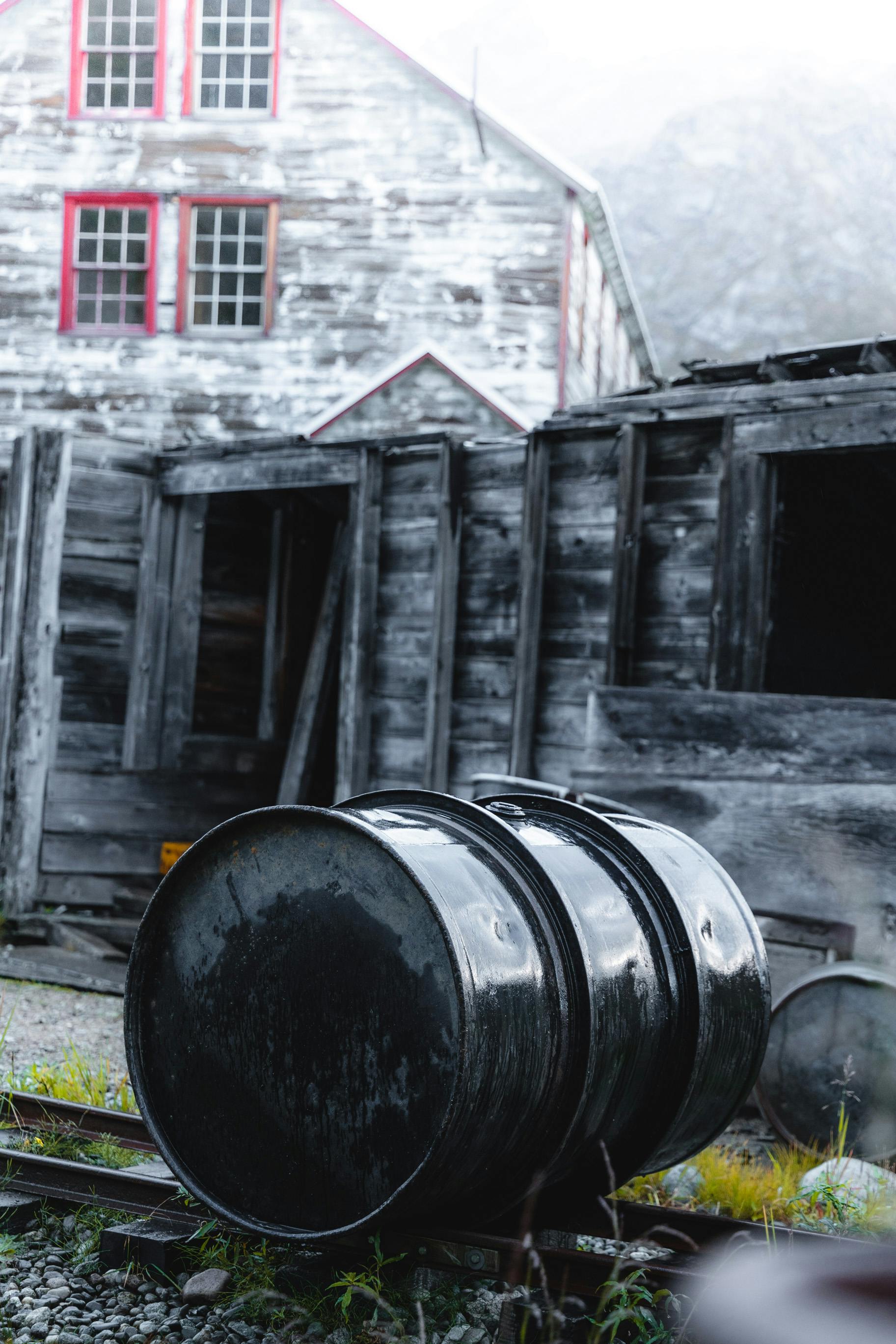 Barrel on Tracks by Wooden Buildings · Free Stock Photo