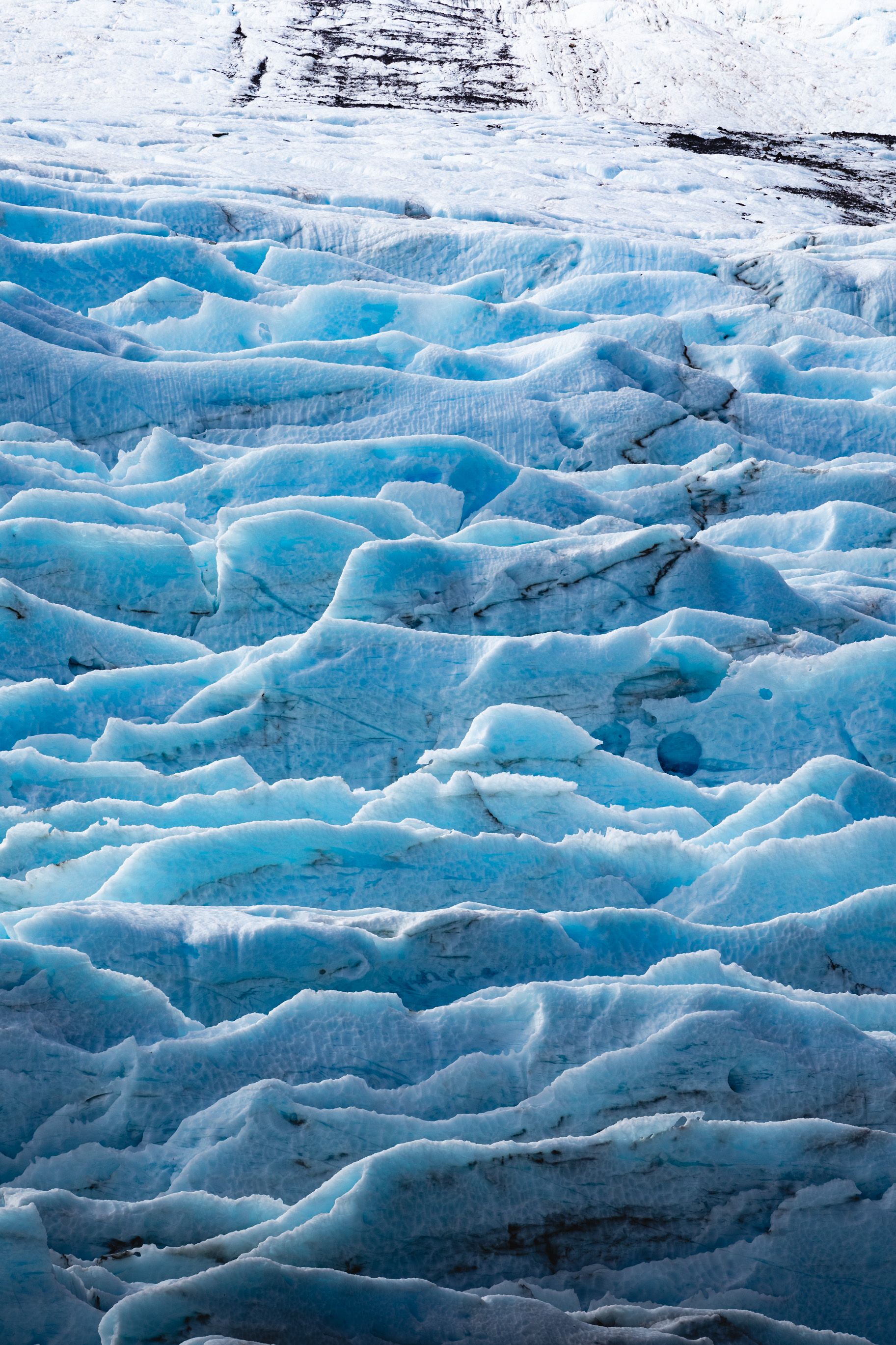 A glacier is covered in blue ice · Free Stock Photo