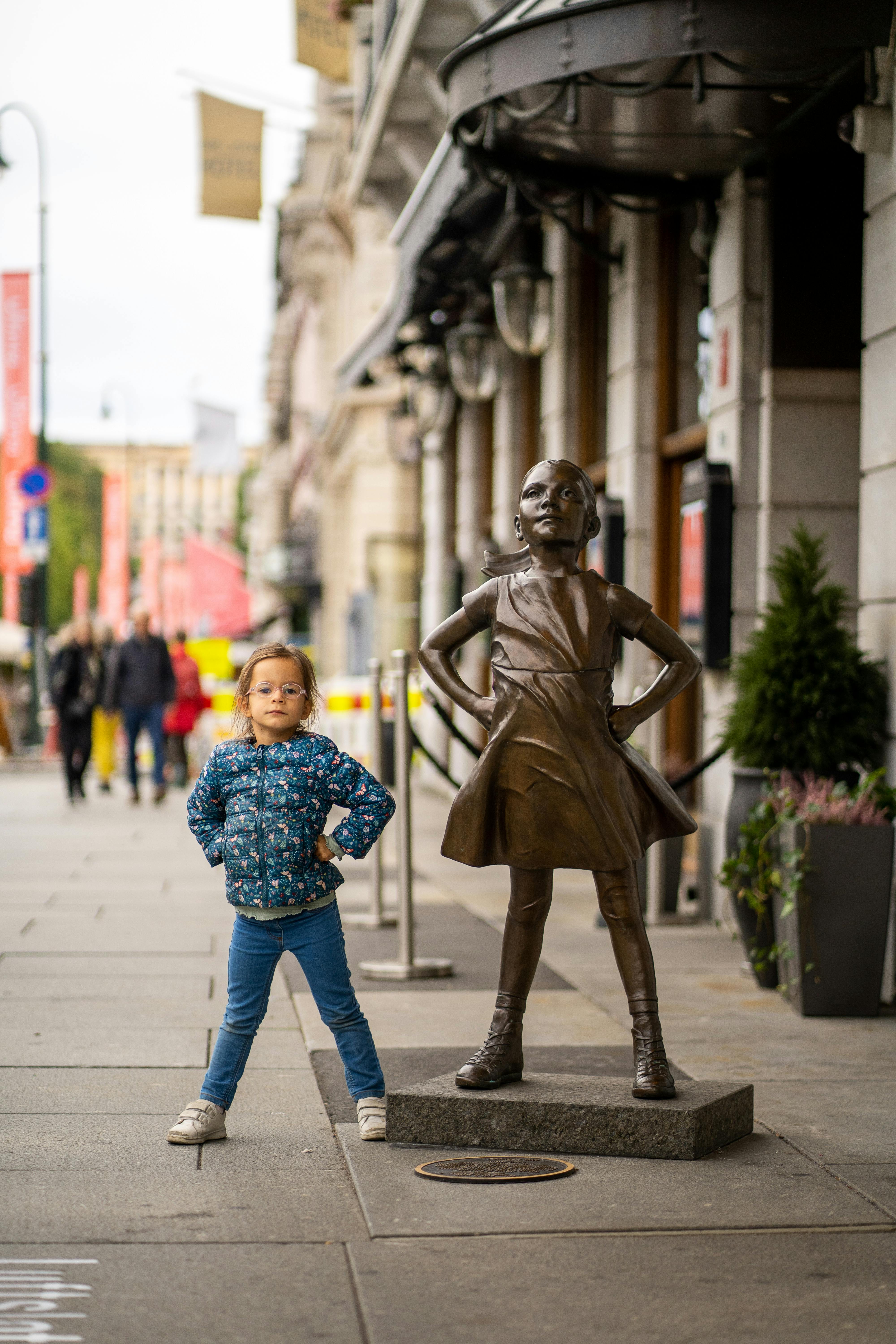 Girl Posing by The Fearless Girl Statue in New York · Free Stock Photo
