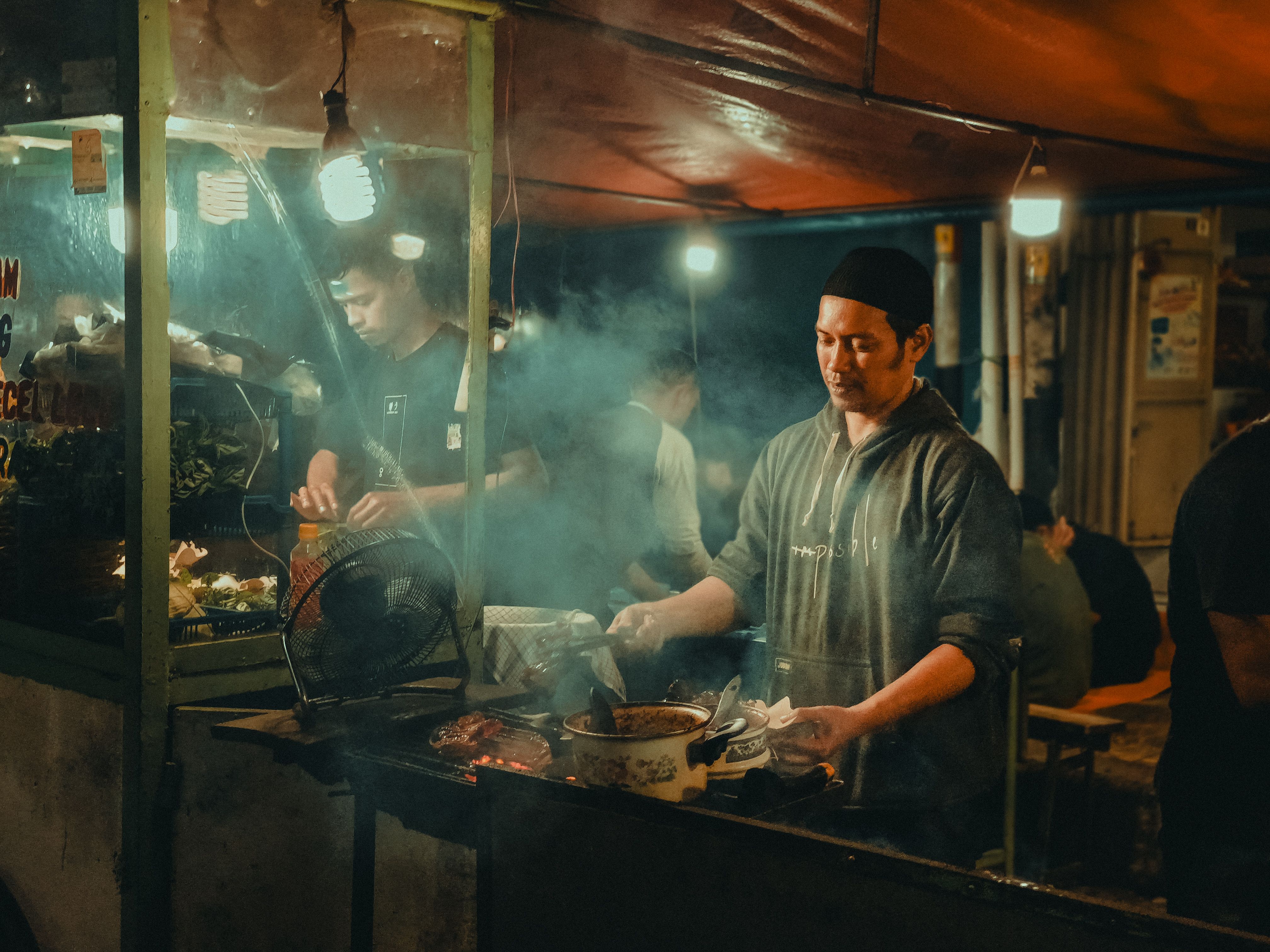 Men Cooking Street Food in a Tent at Night · Free Stock Photo