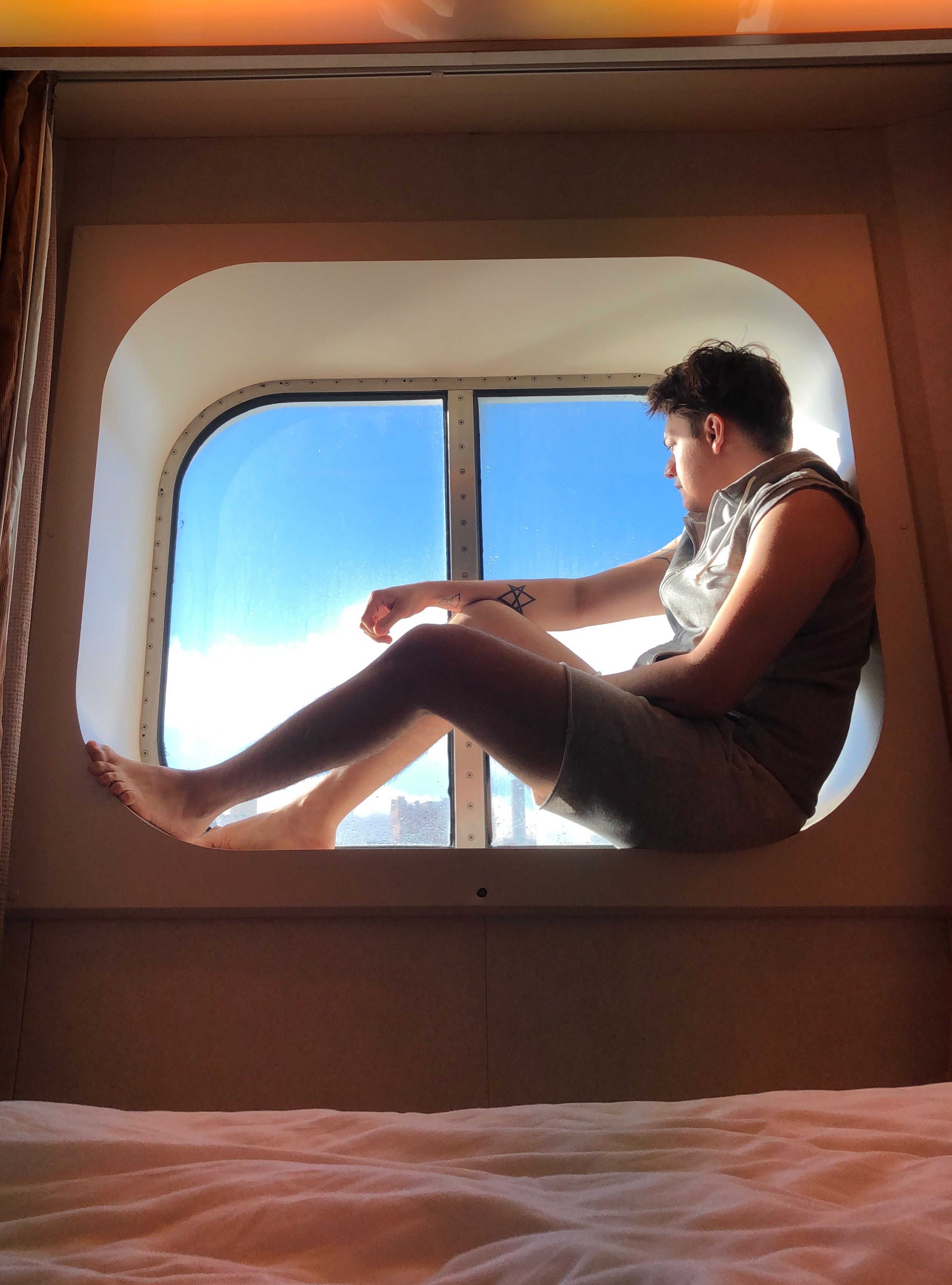 Man Sitting in Window Staring at Blue Sky · Free Stock Photo