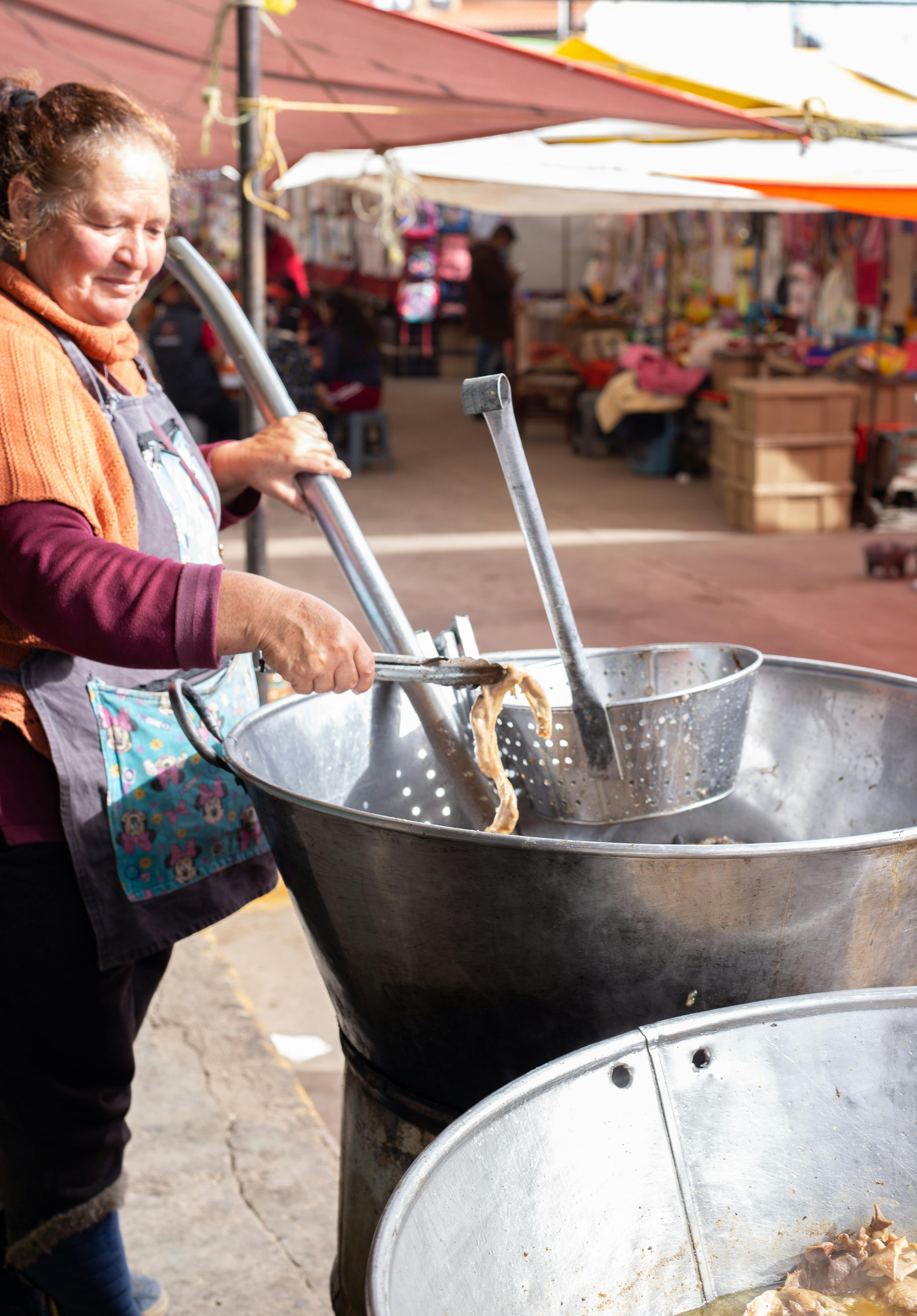 Cook at the Market Preparing Street Food in Cauldrons · Free Stock Photo