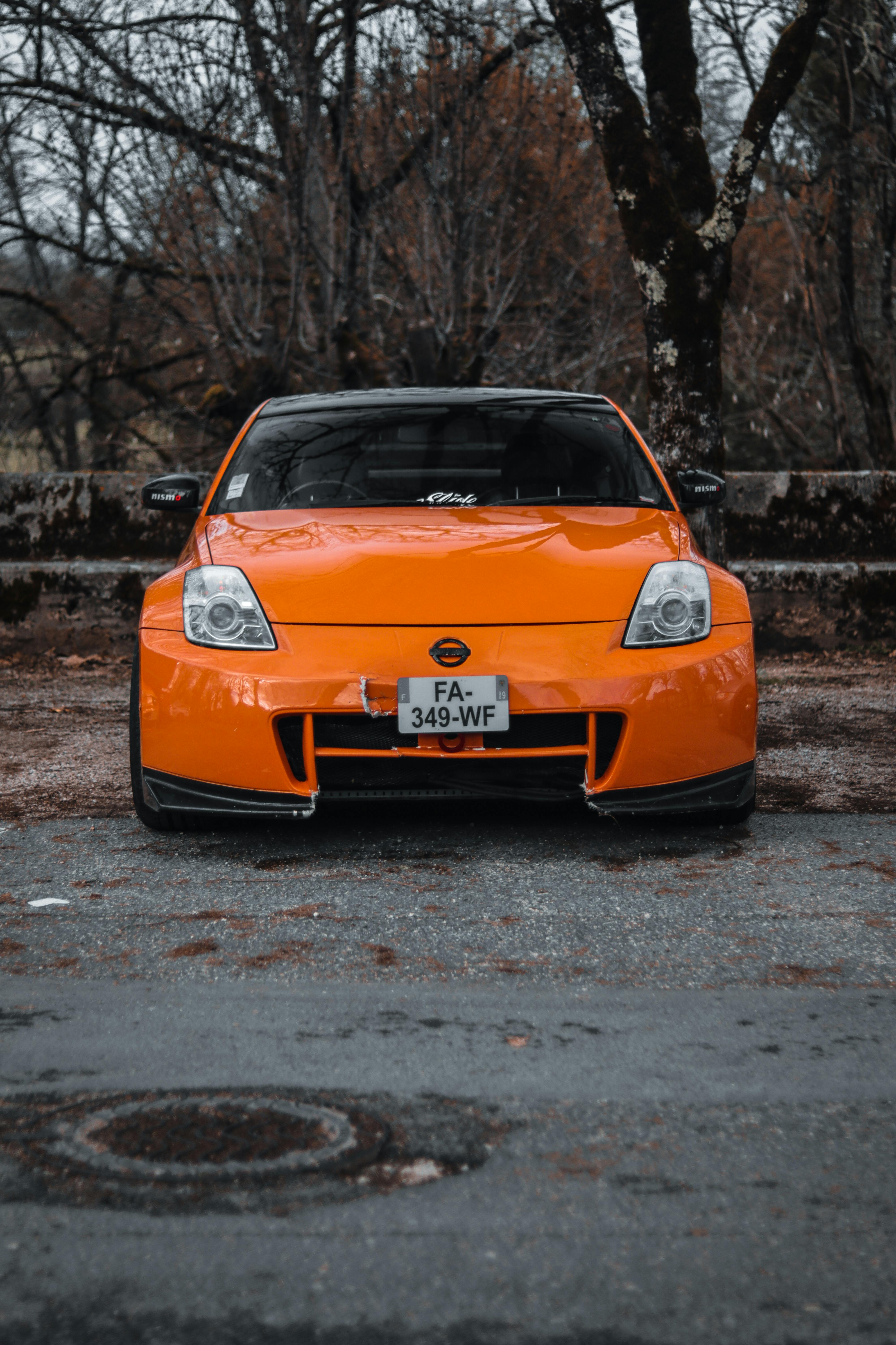 An orange nissan 350z parked in the middle of a parking lot · Free ...